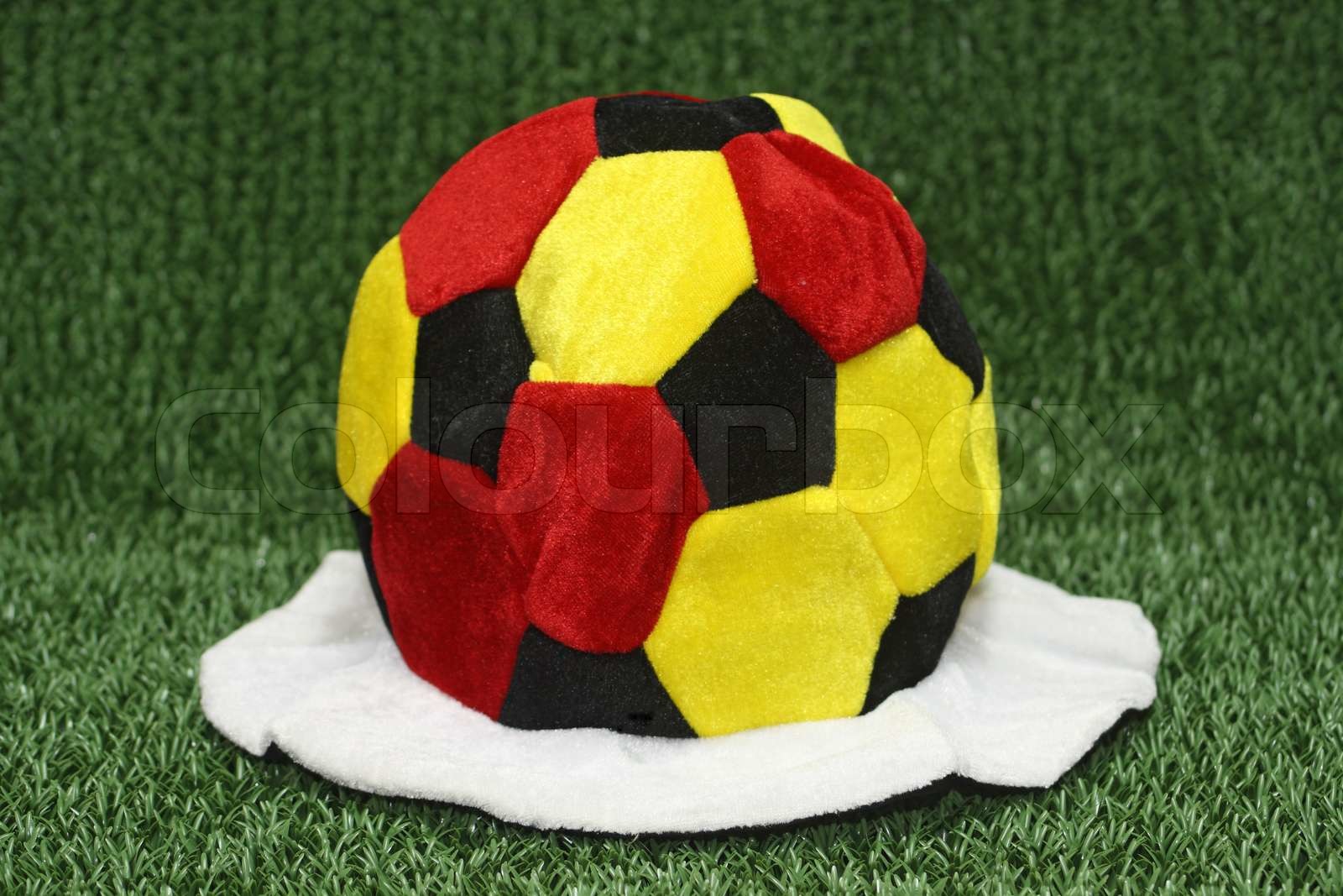 Fodbold cap på tysk flag farver på grøn baggrund | Stock foto | Colourbox