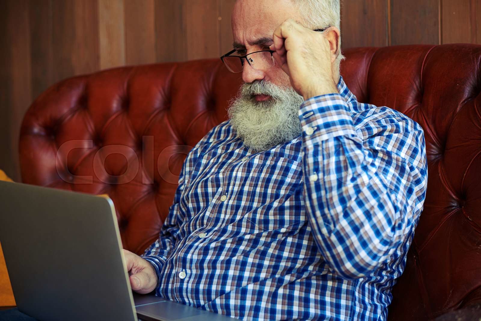old man sitting on couch and working with laptop | Stock image | Colourbox