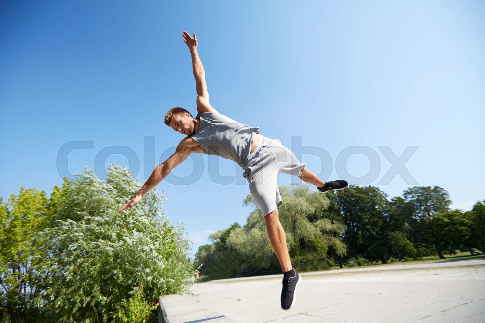 sporty young man jumping in summer park | Stock image | Colourbox