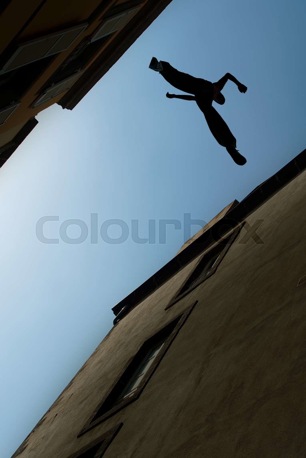 Man jumping over building roof vertical image | Stock image | Colourbox