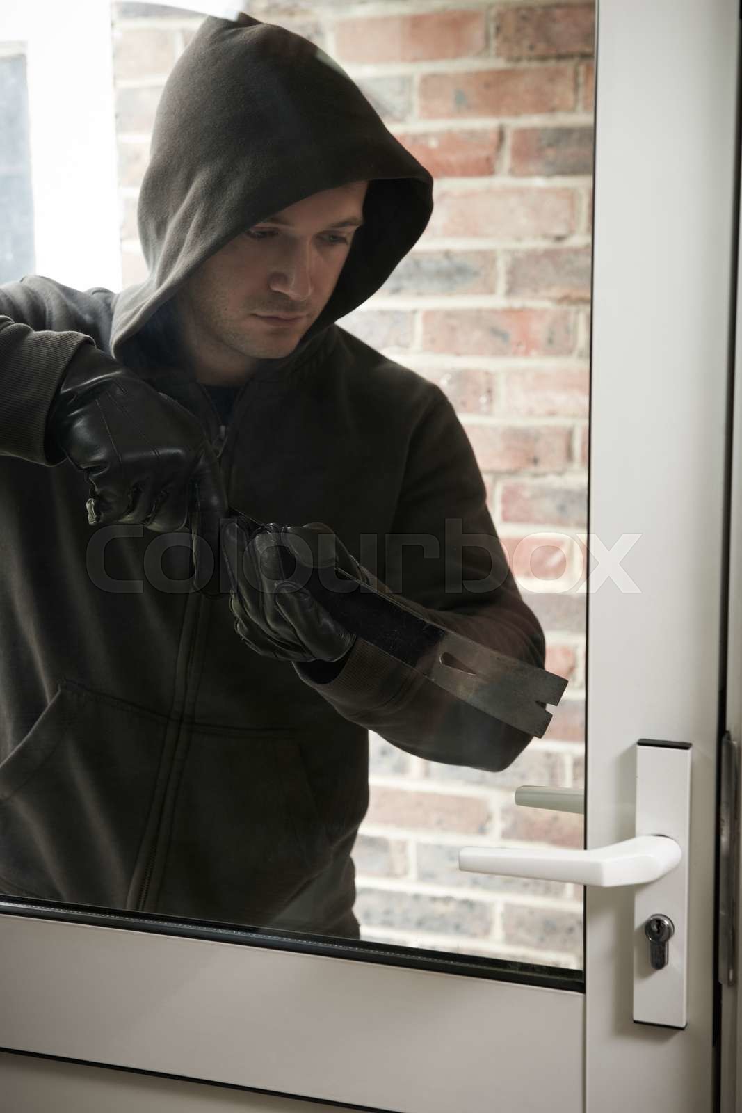Man Using Crowbar To Break Into House | Stock image | Colourbox