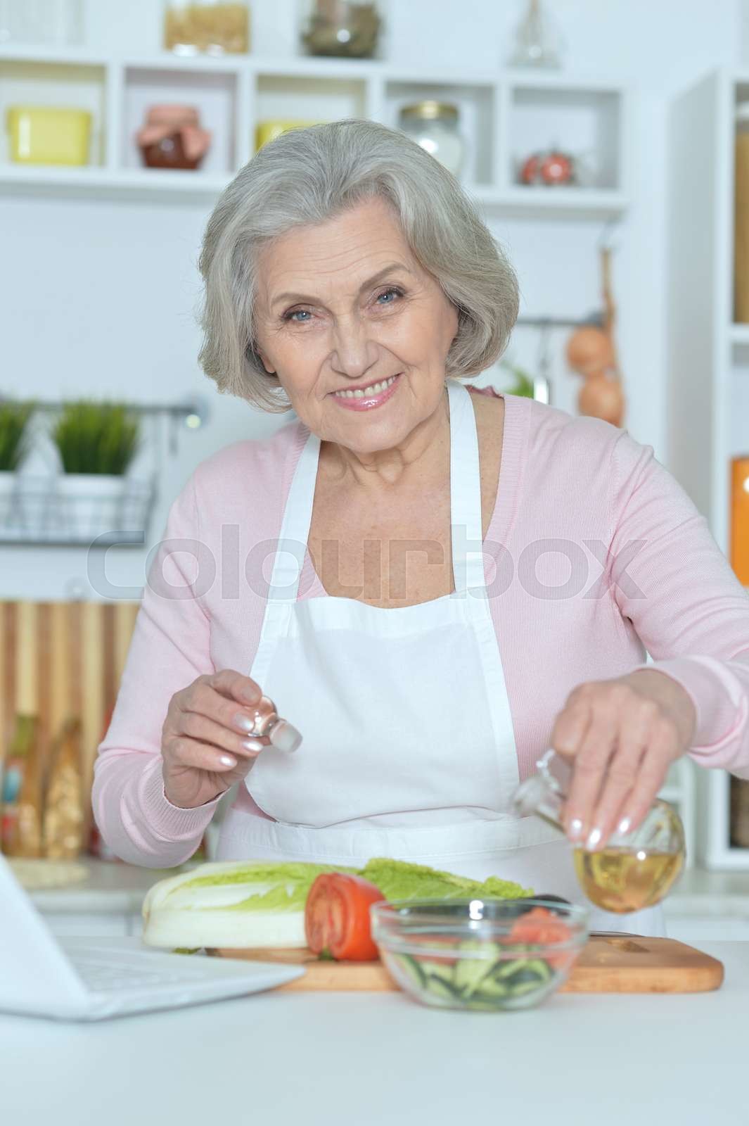 Senior woman cooking in kitchen | Stock image | Colourbox