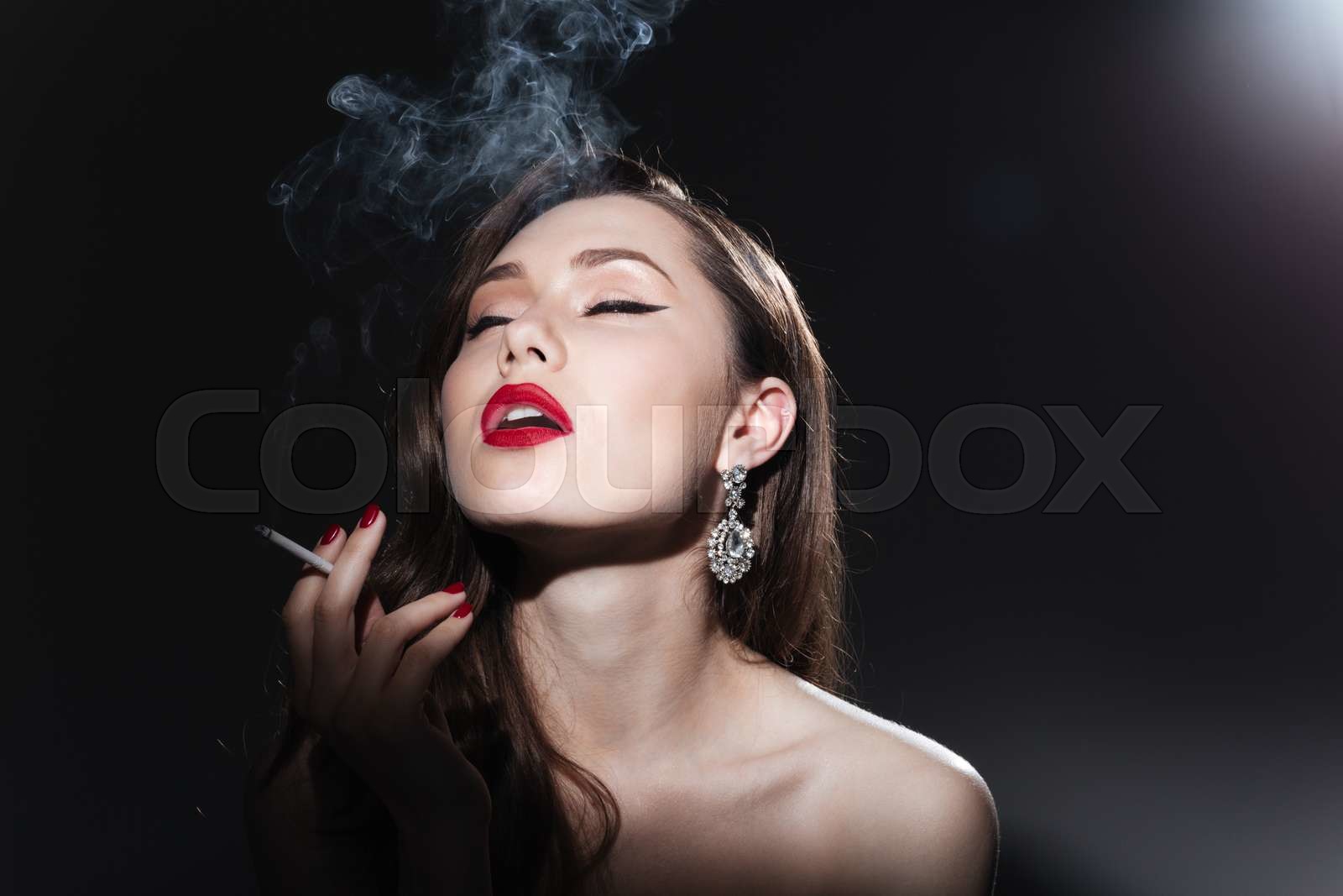 Beautiful woman smoking cigarette | Stock image | Colourbox