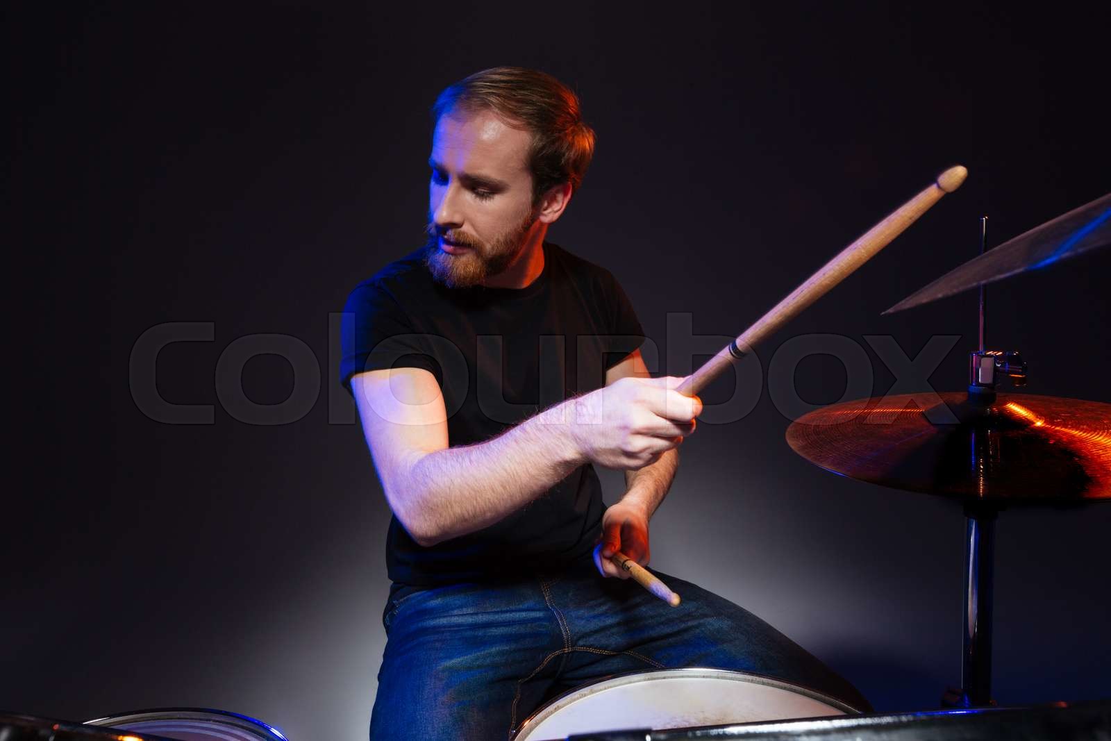 Bearded man drummer with closed eyes sitting and playing drums | Stock ...