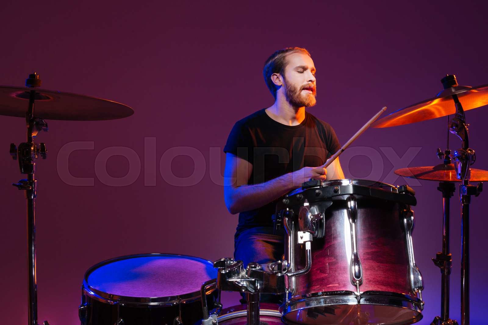 Handsome man drummer sitting and playing on his kit | Stock image ...
