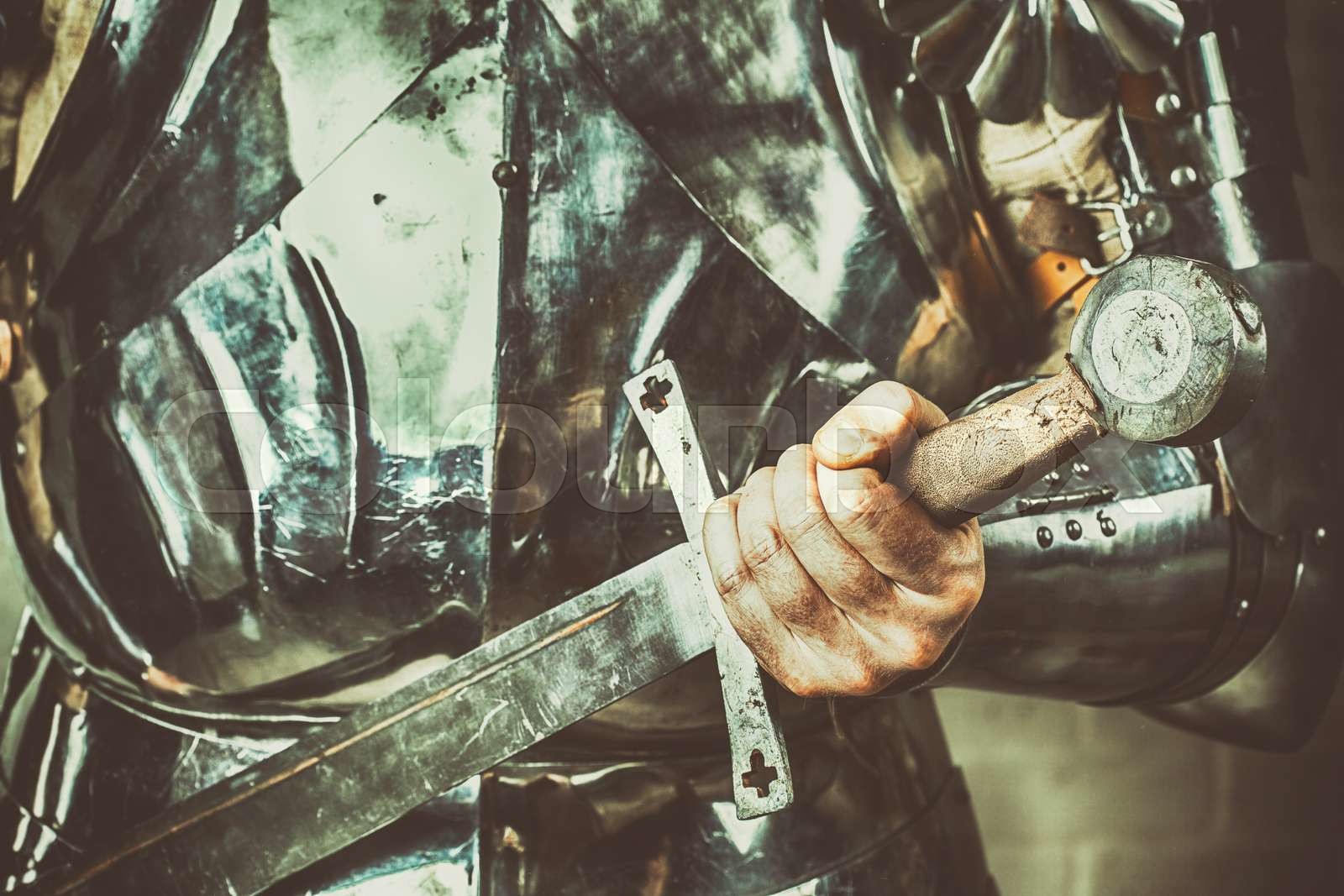 knight wearing armor and holding two-handed sword | Stock image | Colourbox