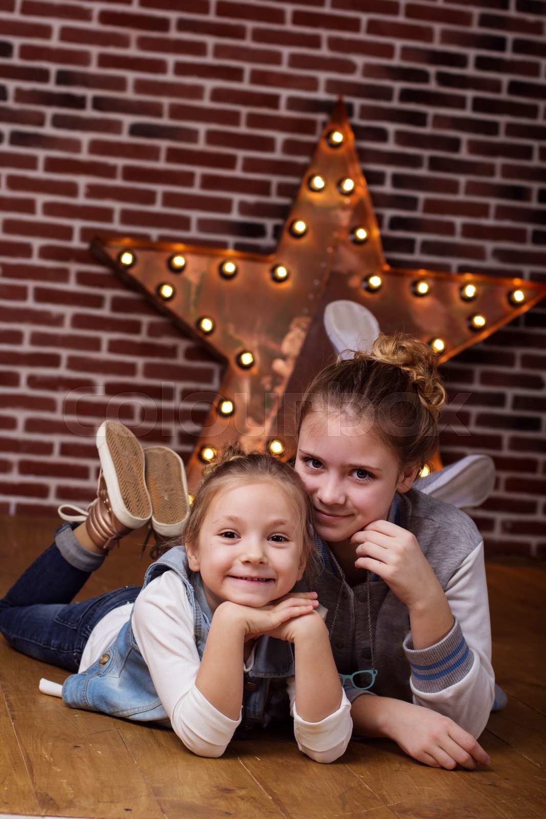 Pretty girls at home infront brick wall | Stock image | Colourbox