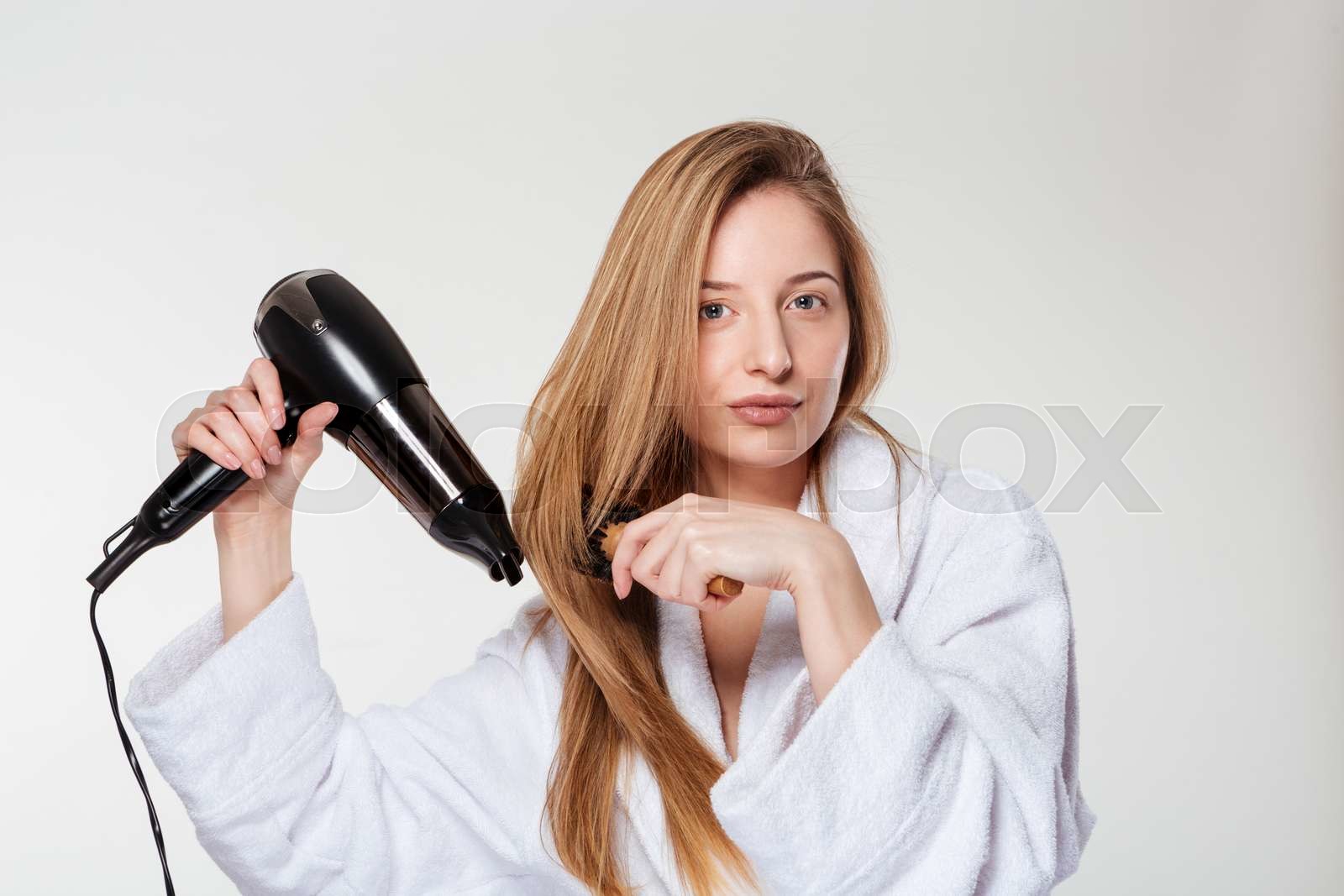 Attractive woman drying her hair | Stock image | Colourbox