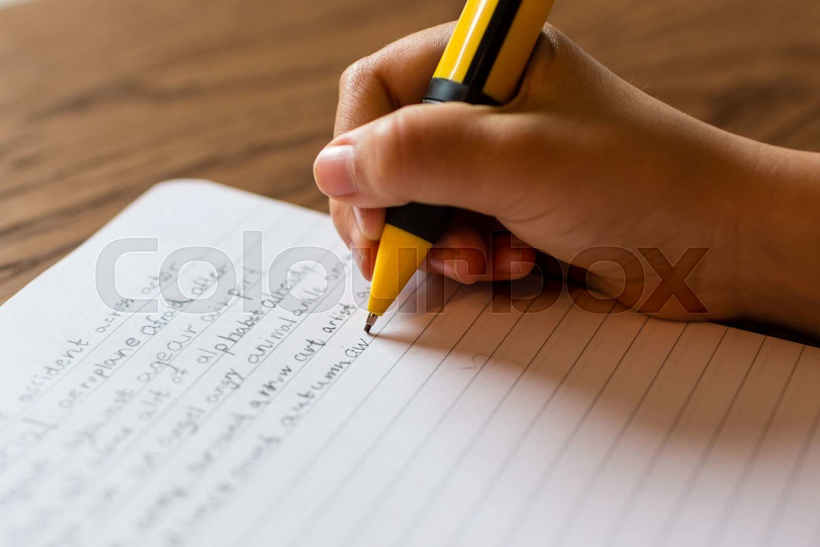 Person writing by hand on notepad | Stock image | Colourbox