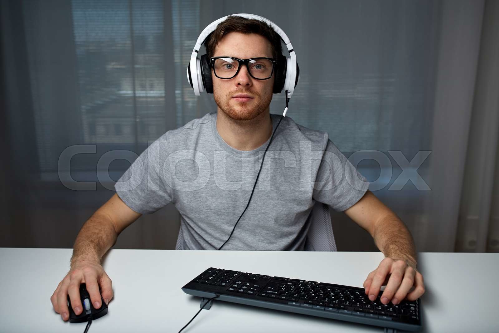 man in headset playing computer video game at home | Stock image ...