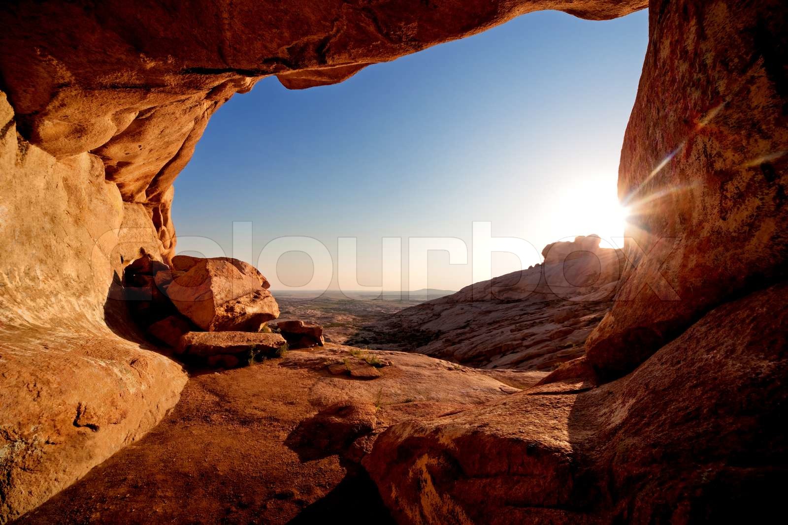 Entrance to cave and the sunset in desert mountains | Stock image ...