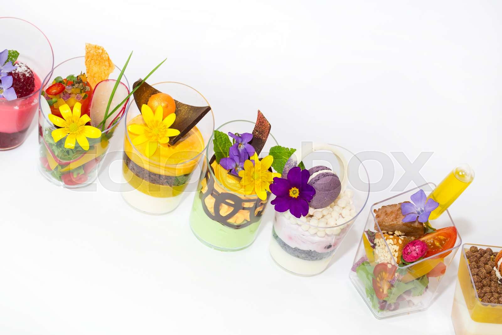 mini canapes in plastic cups decorated with edible flowers | Stock ...