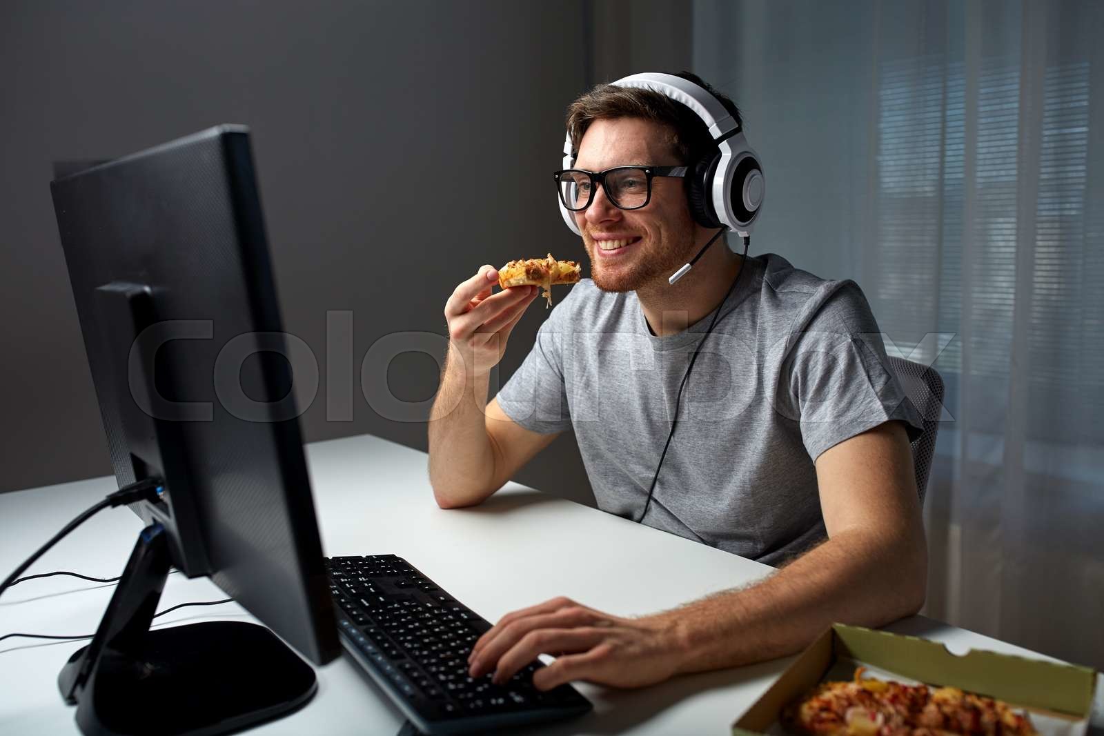 man in headset playing computer video game at home | Stock image ...
