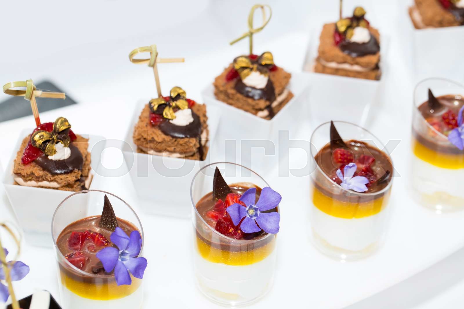 mini canapes in plastic cups decorated with edible flowers | Stock ...