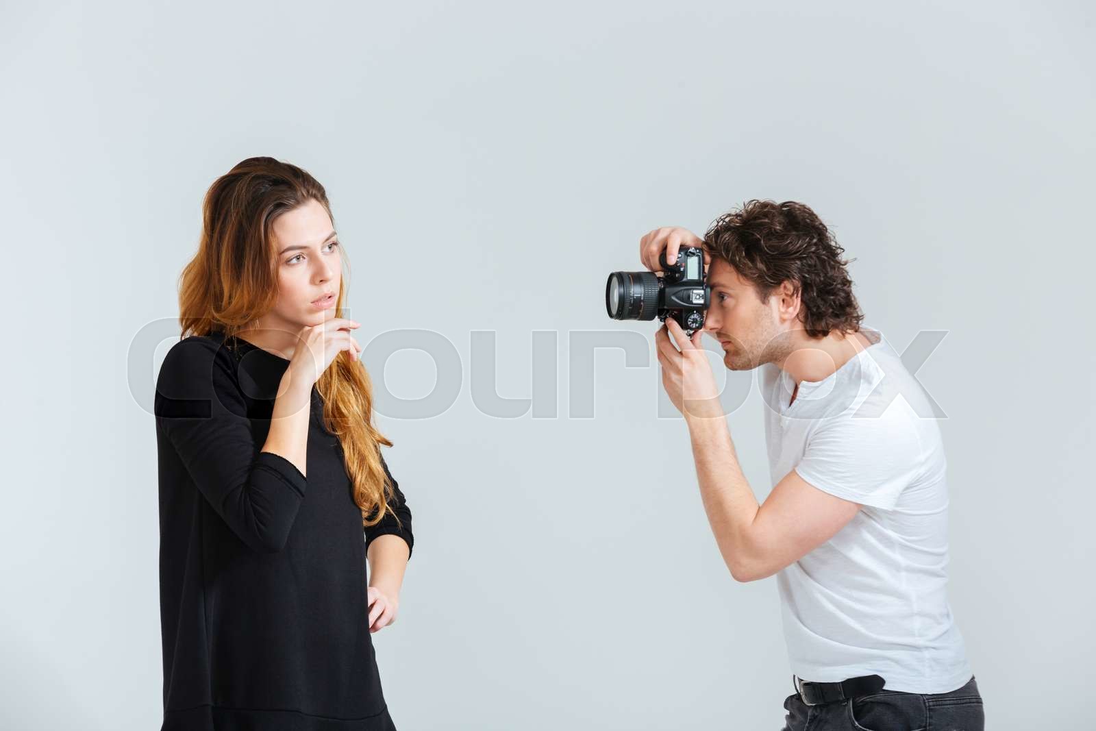 Man photographing female model | Stock image | Colourbox