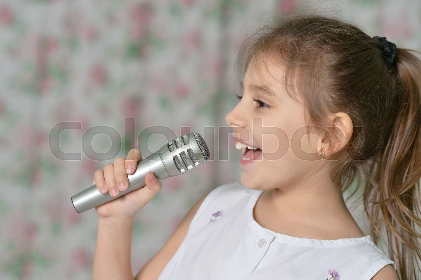Beautiful little girl with microphone | Stock image | Colourbox