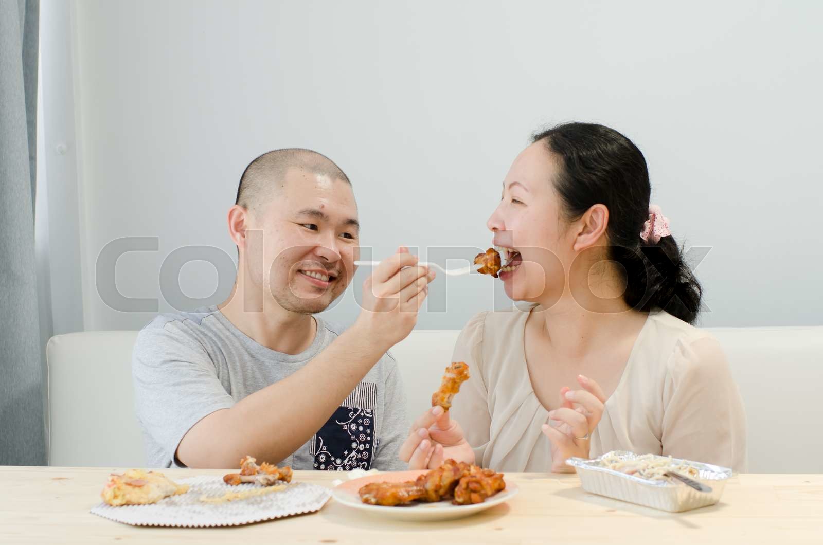 Happy lover eating fried chicken at home. | Stock image | Colourbox