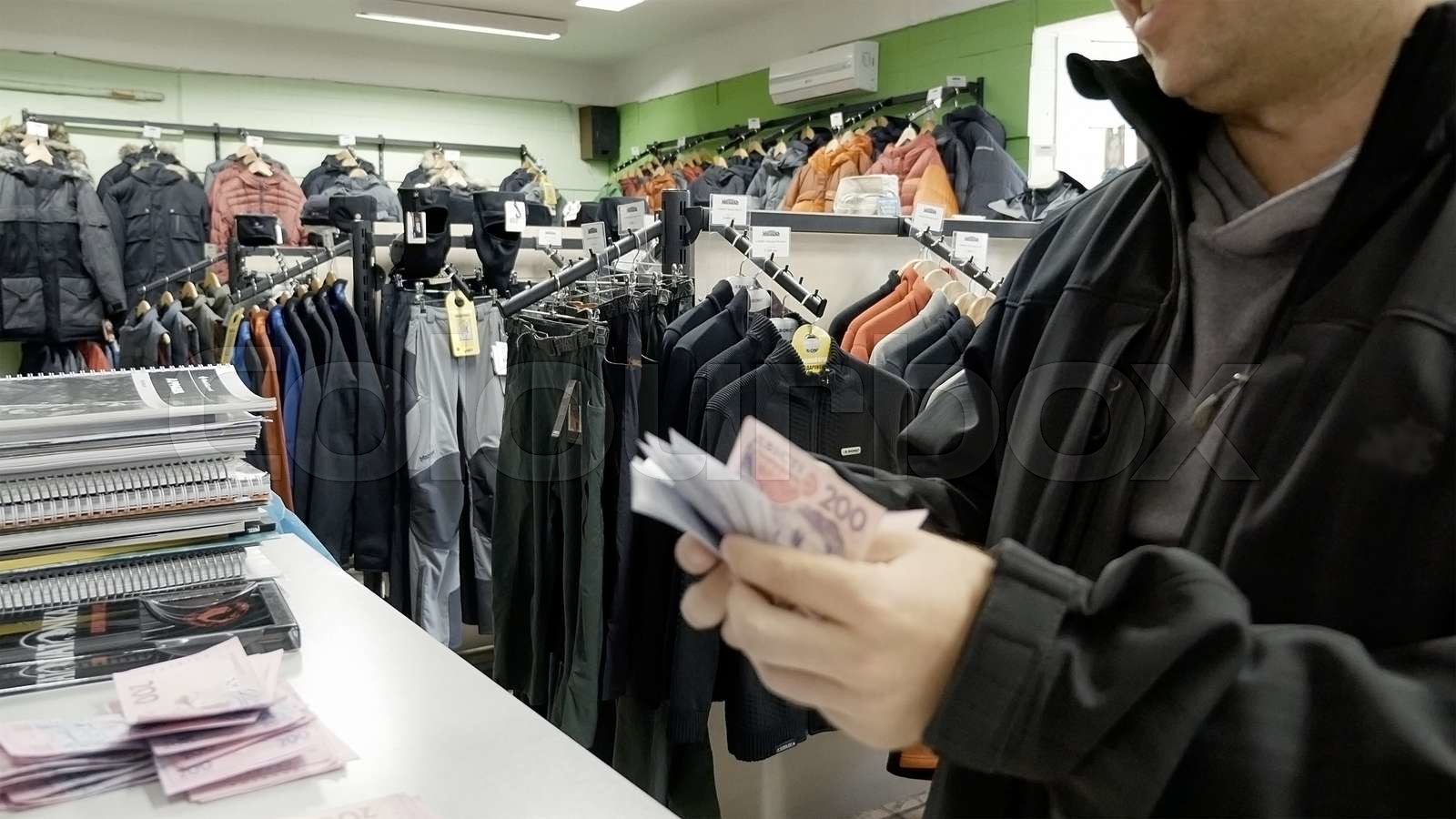 Man pays money in cash in the clothing store shop | Stock image | Colourbox