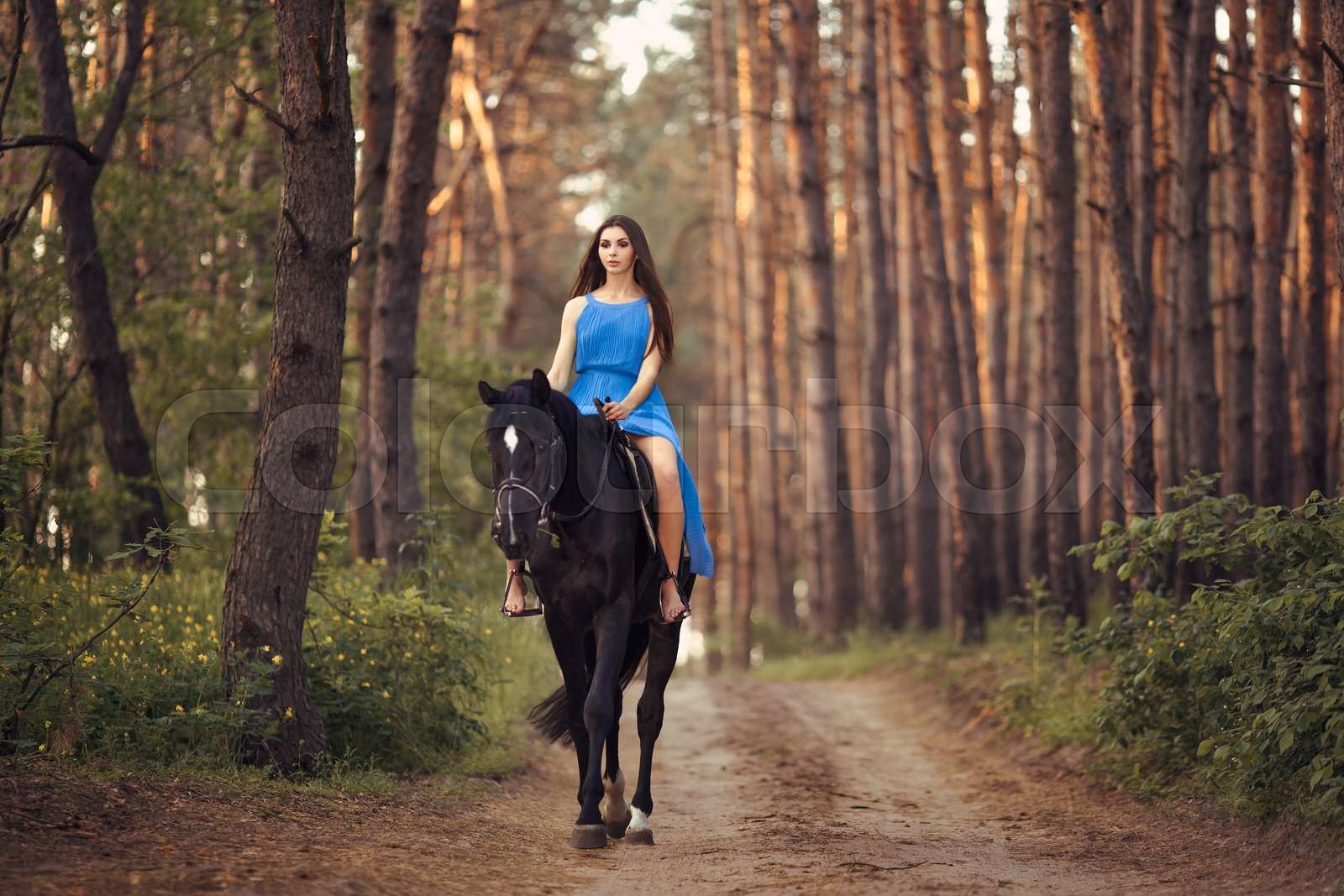 Beautiful woman riding horse in forest | Stock image | Colourbox