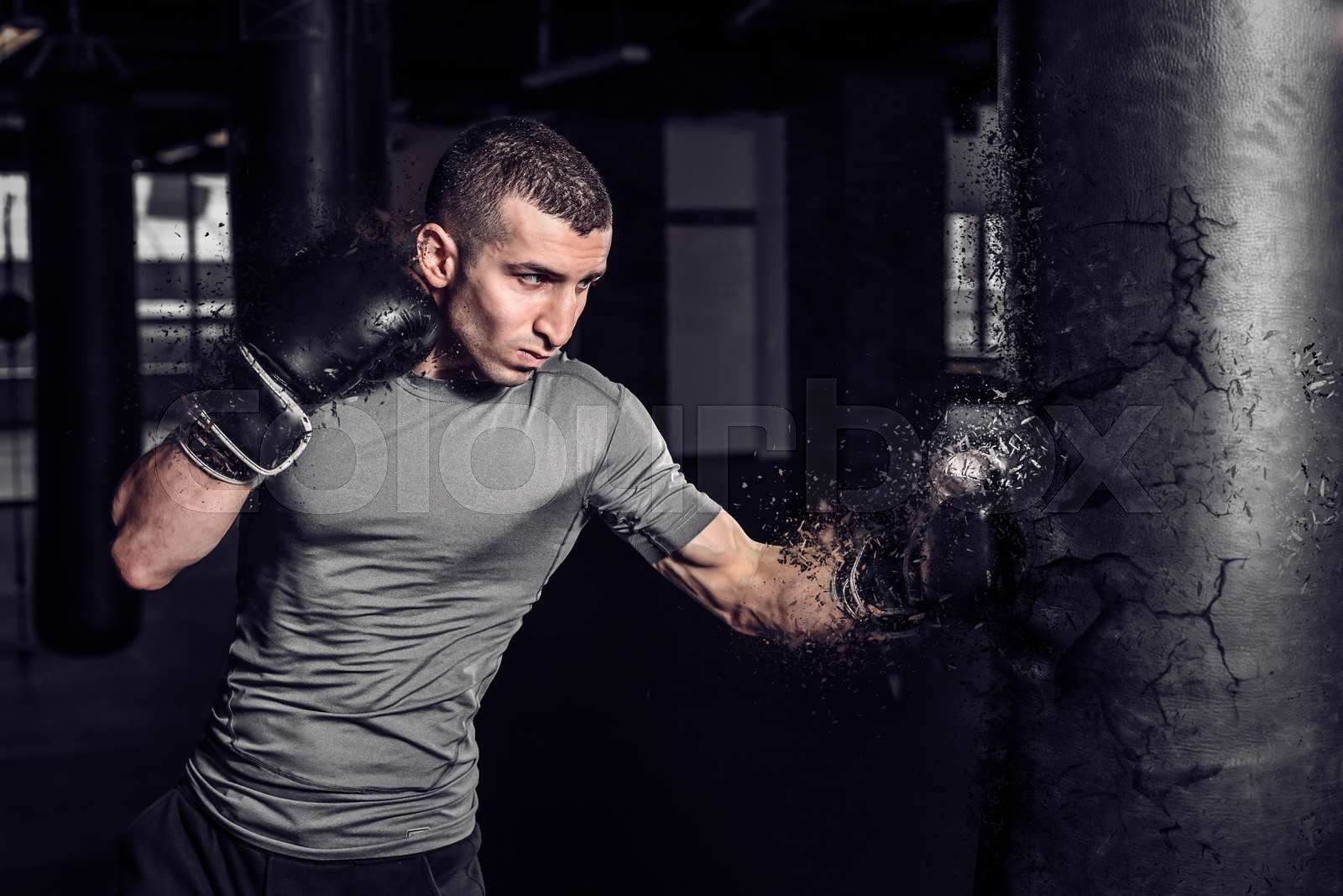 Boxer punch punching bag exploding in gym | Stock image | Colourbox