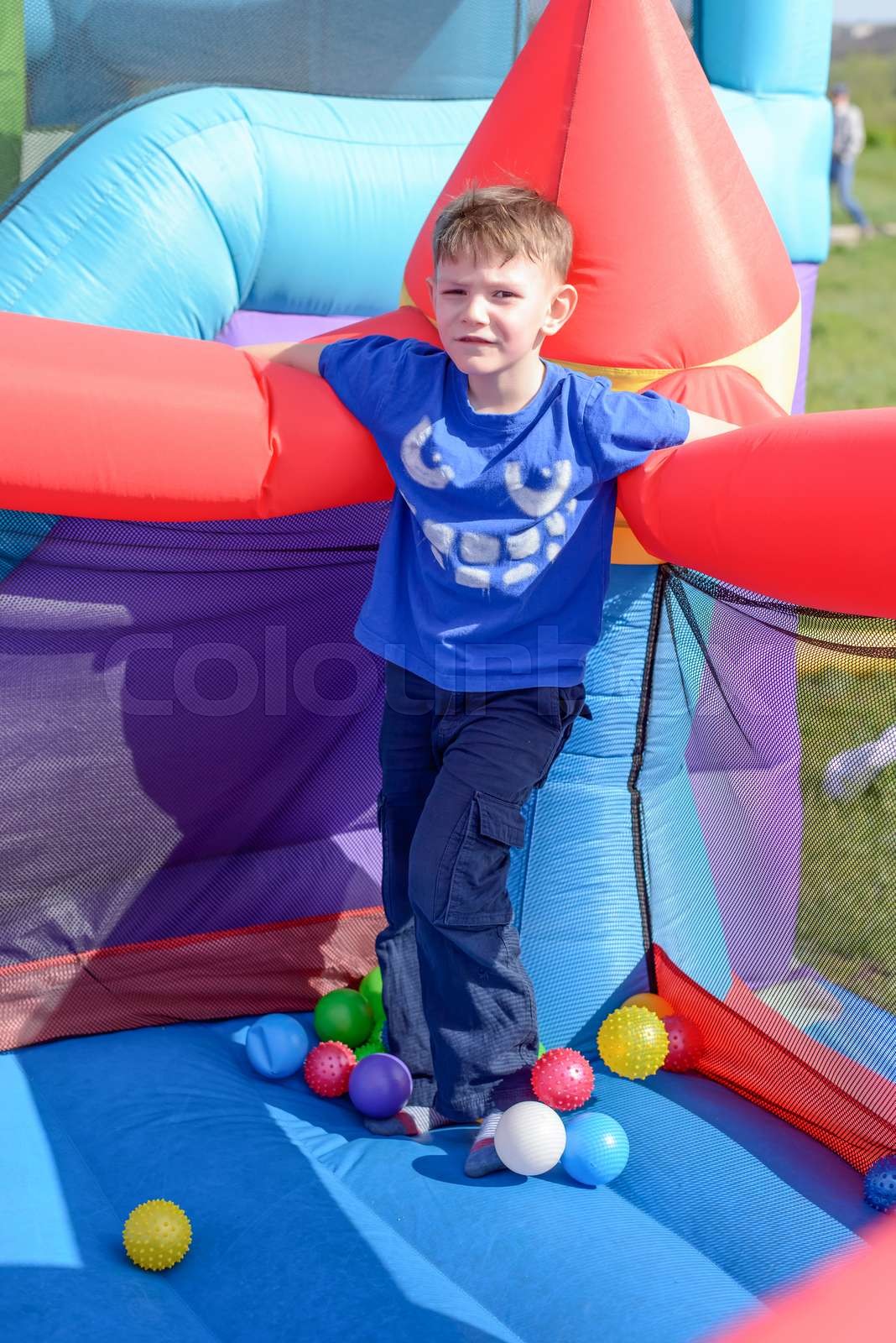 Handsome little boy standing on a bouncy castle | Stock image | Colourbox