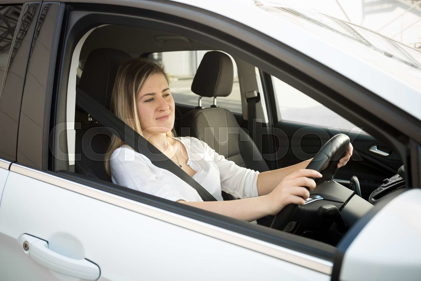 Portrait of blonde woman driving car | Stock image | Colourbox