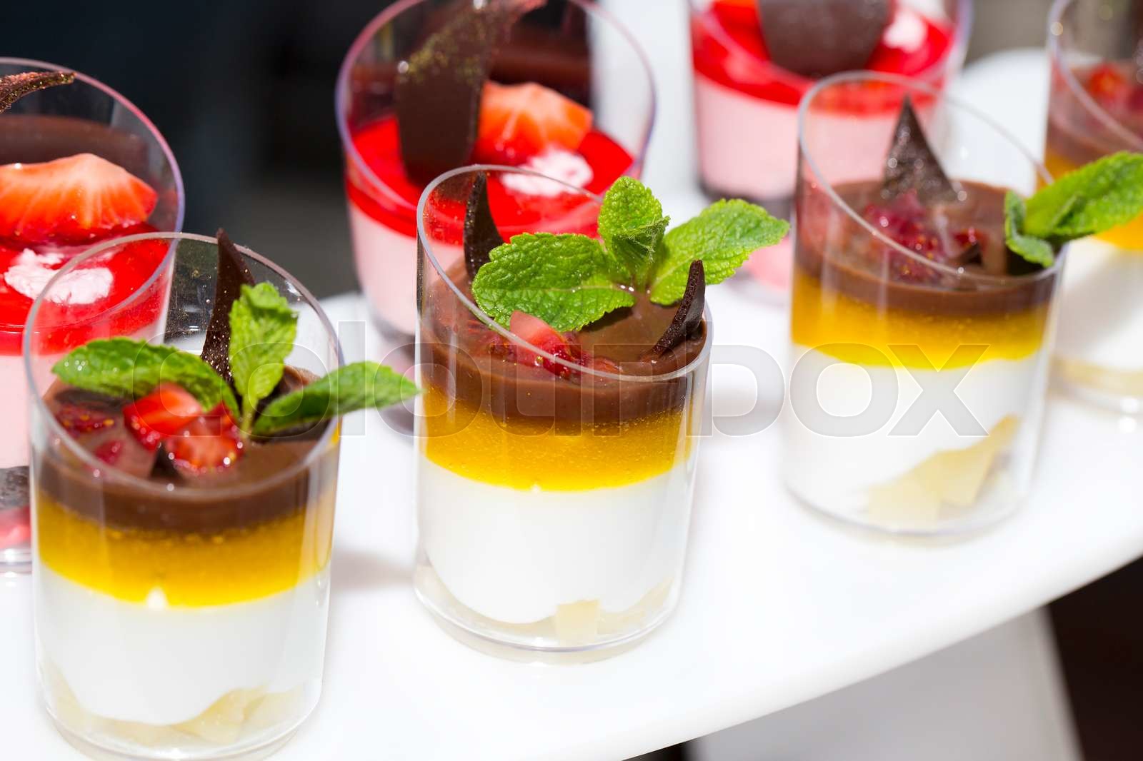 mini canapes in plastic cups decorated with edible flowers | Stock ...