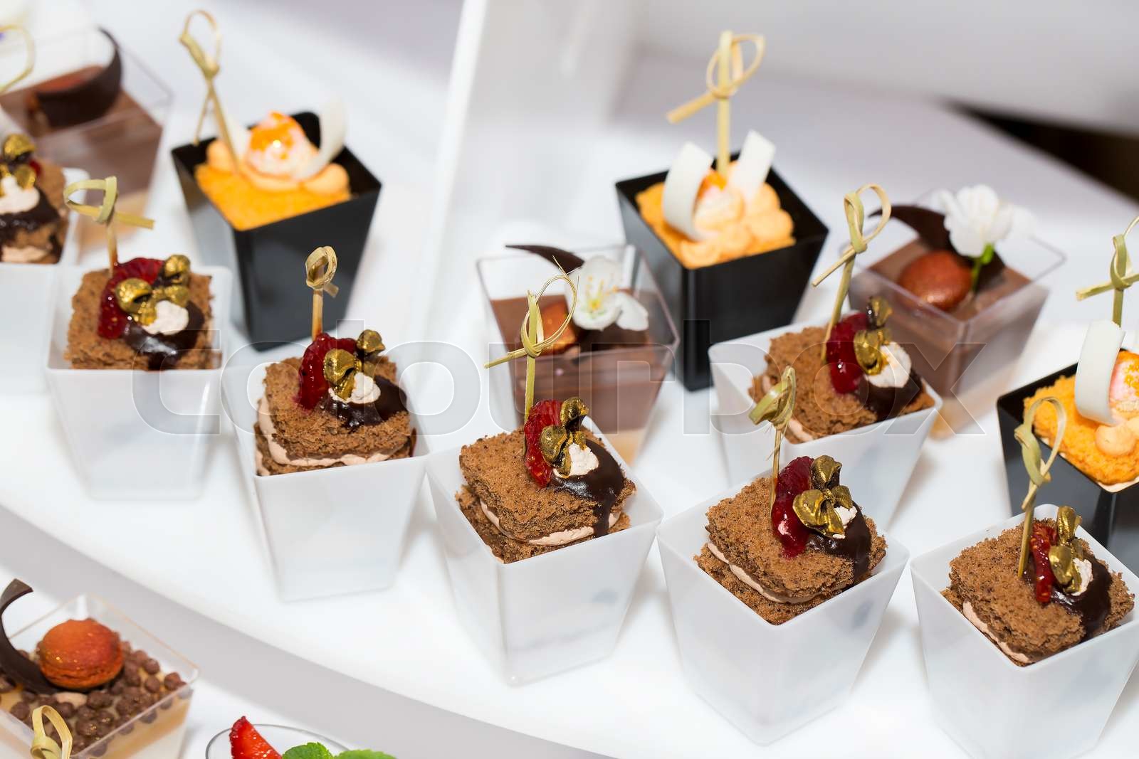 mini canapes in plastic cups decorated with edible flowers | Stock ...