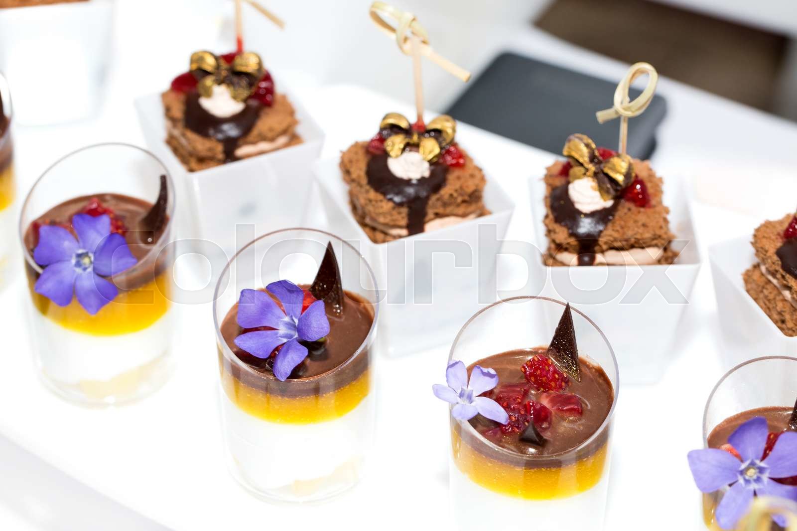 mini canapes in plastic cups decorated with edible flowers | Stock ...