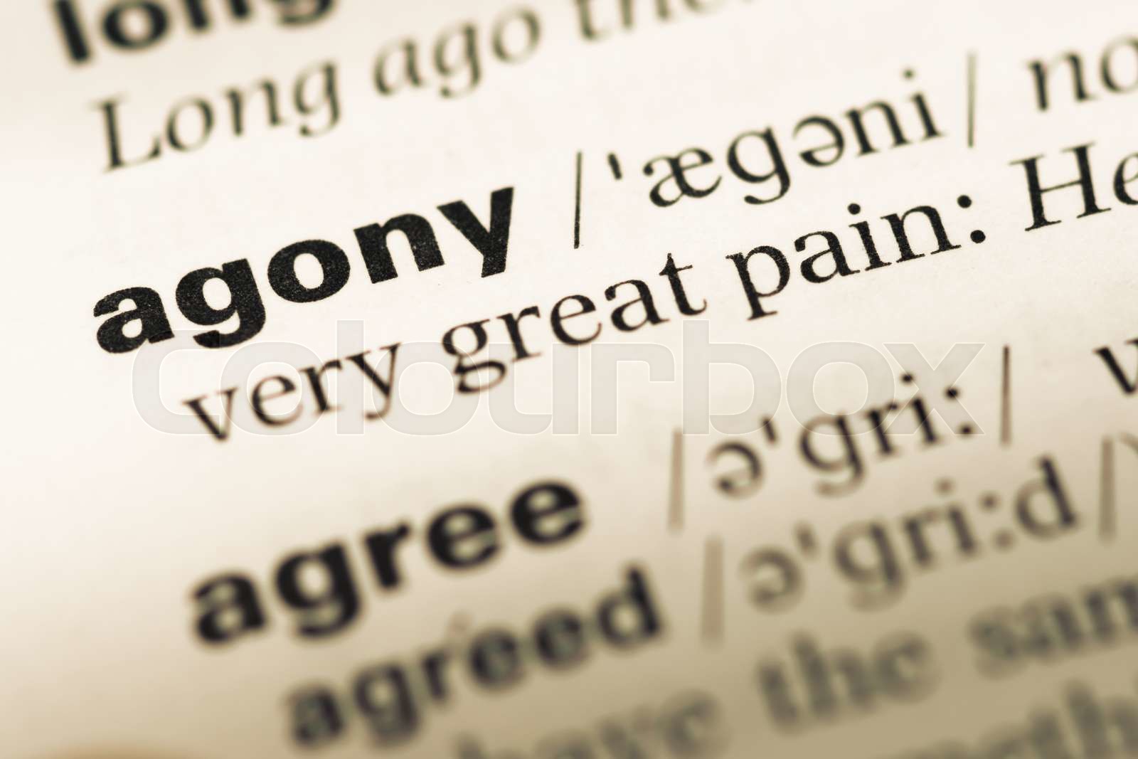 Close Up Of Old English Dictionary Page With Word Agony Stock Image