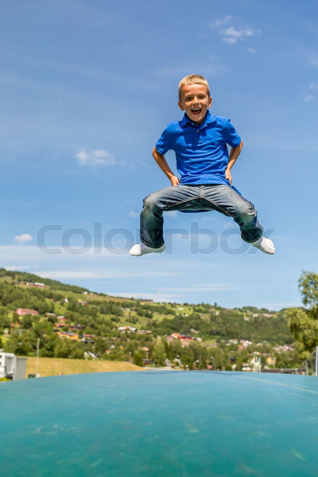 Young boy jumping on bouncing pillow | Stock image | Colourbox