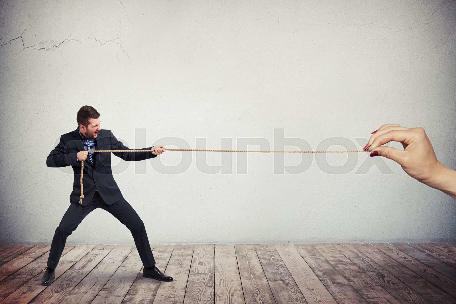 Man in business suit is pulling the rope | Stock image | Colourbox