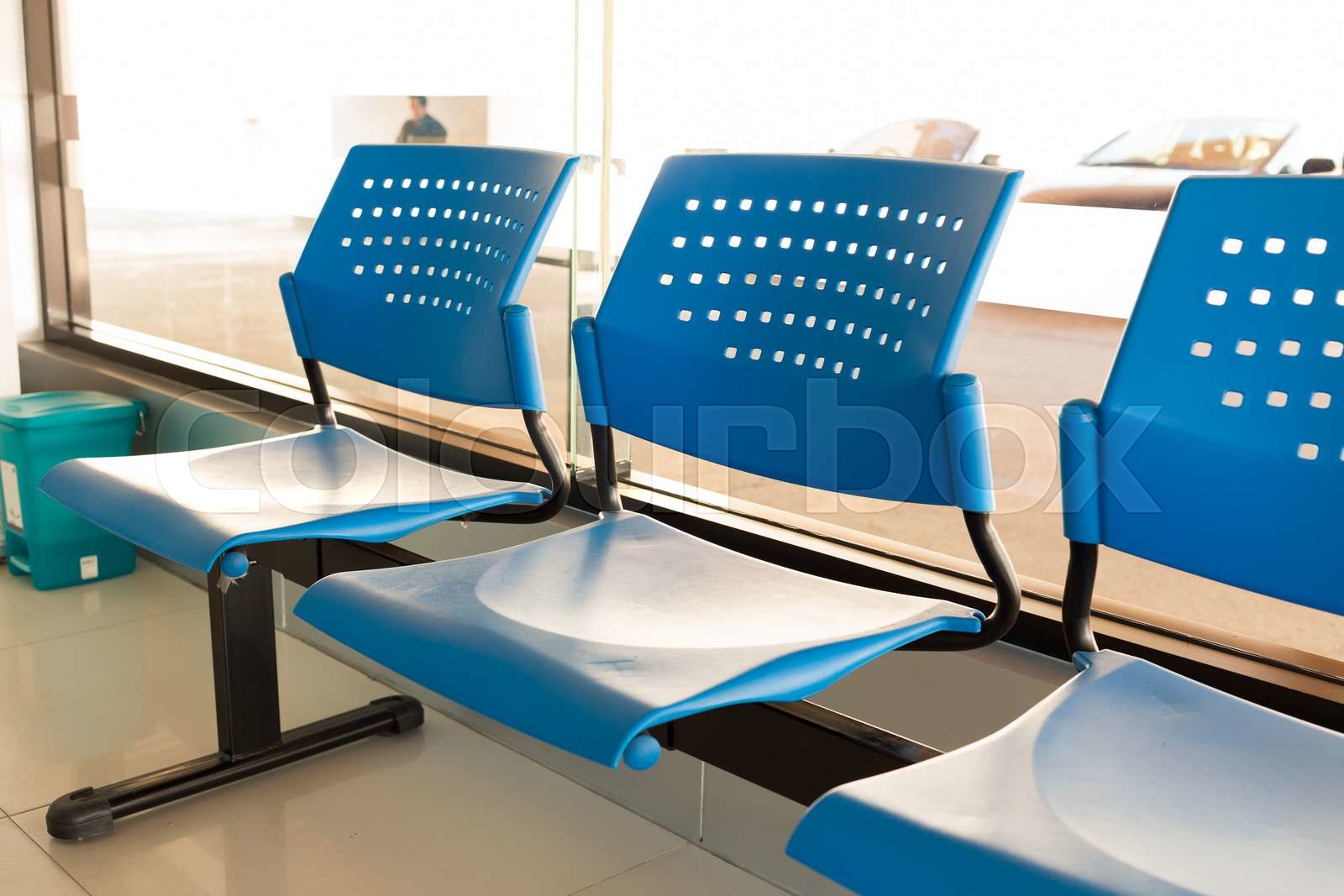 customer waiting area with rows of blue seats in office | Stock image ...