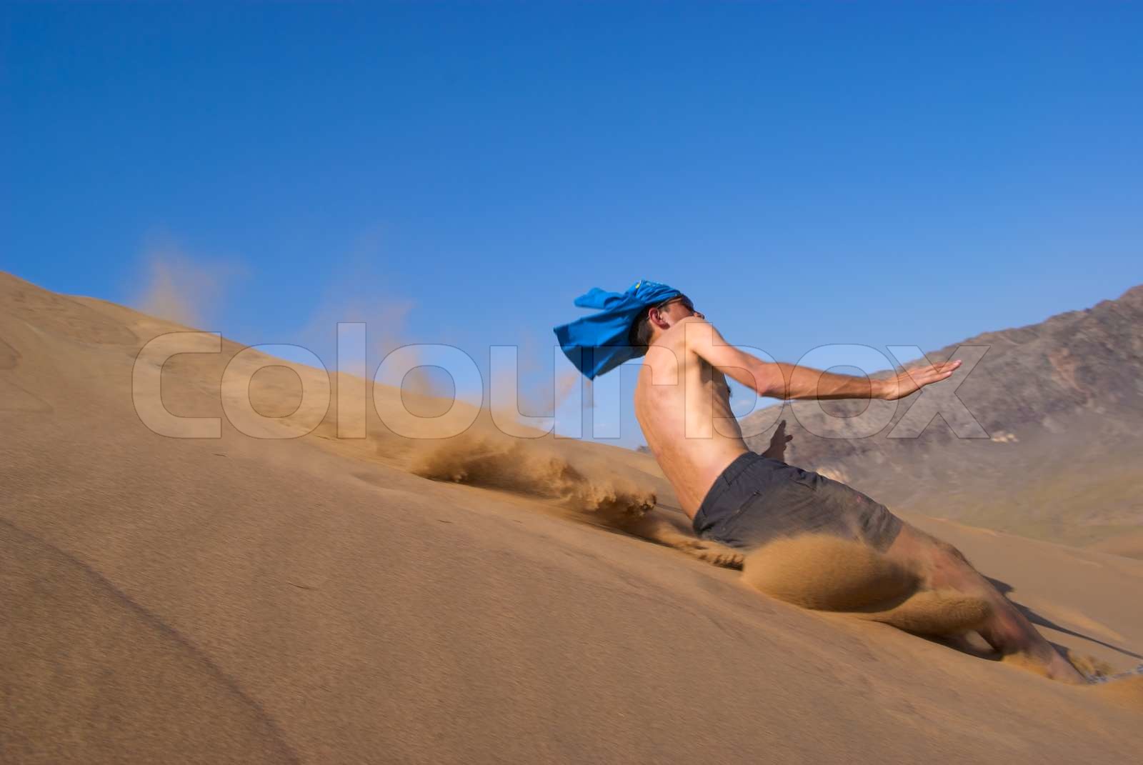 Fun jumping on sand dune - blurred motion | Stock image | Colourbox