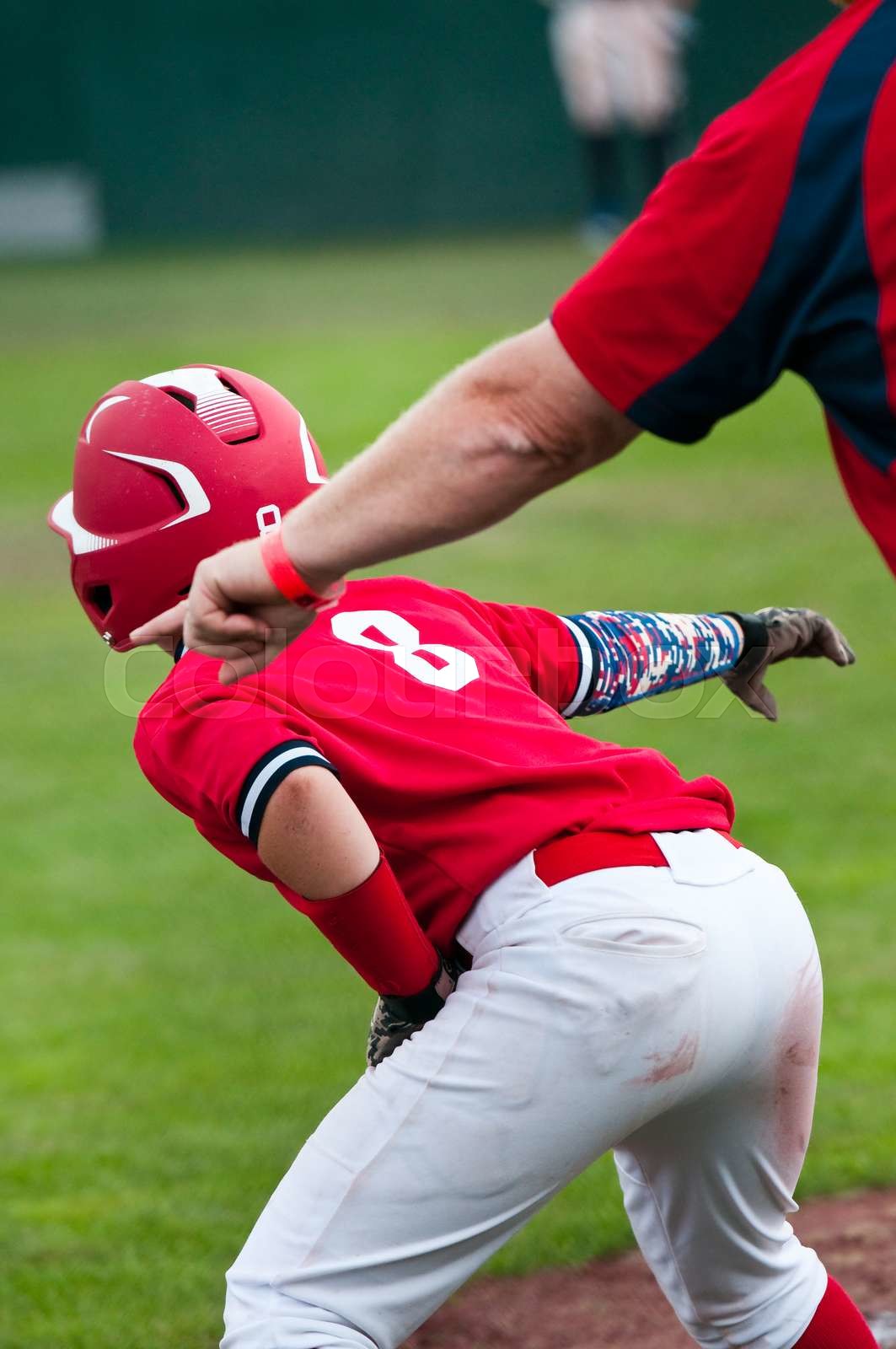 Youth baseball player on base with coach | Stock image | Colourbox