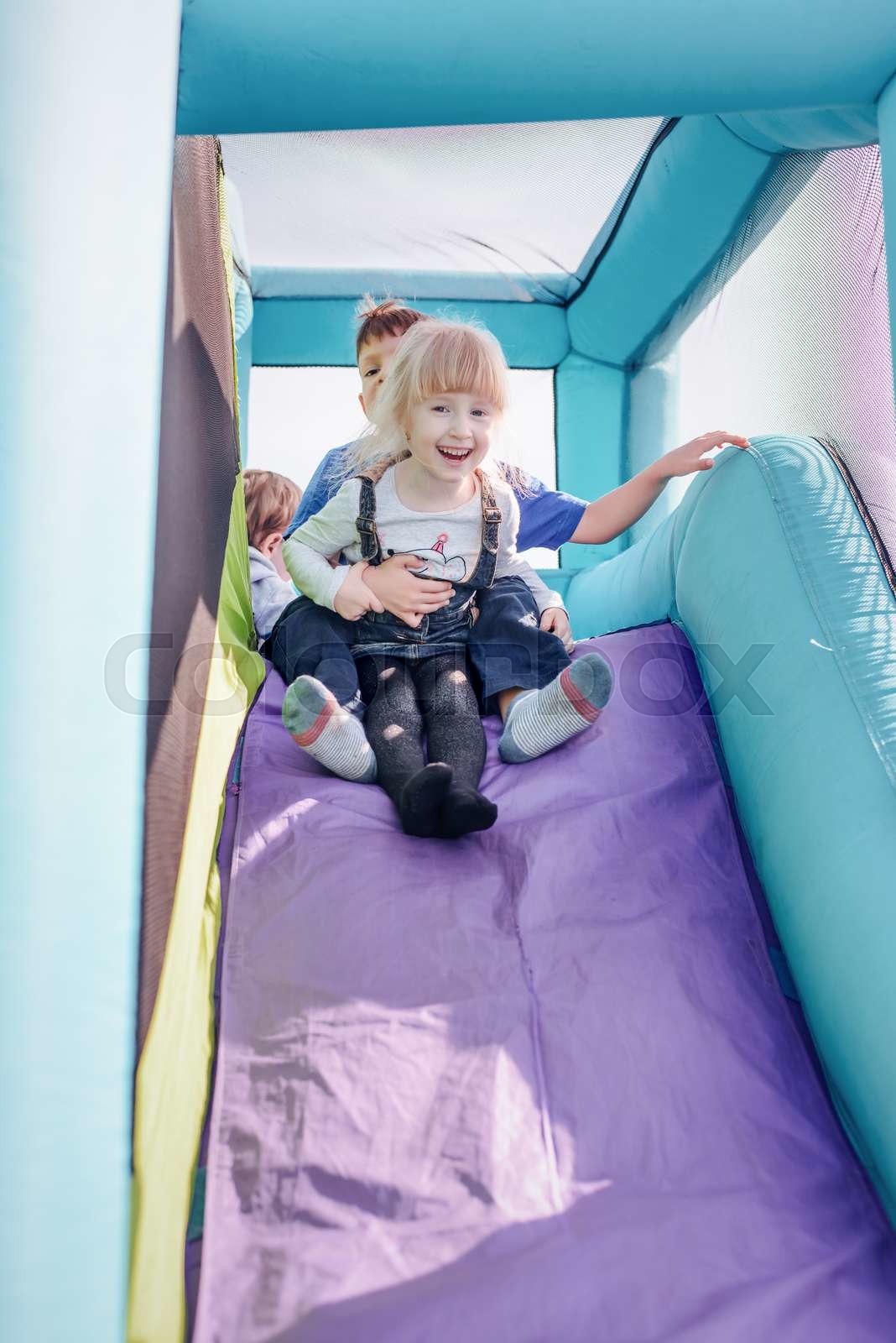 Children going down inflatable bouncy slide | Stock image | Colourbox