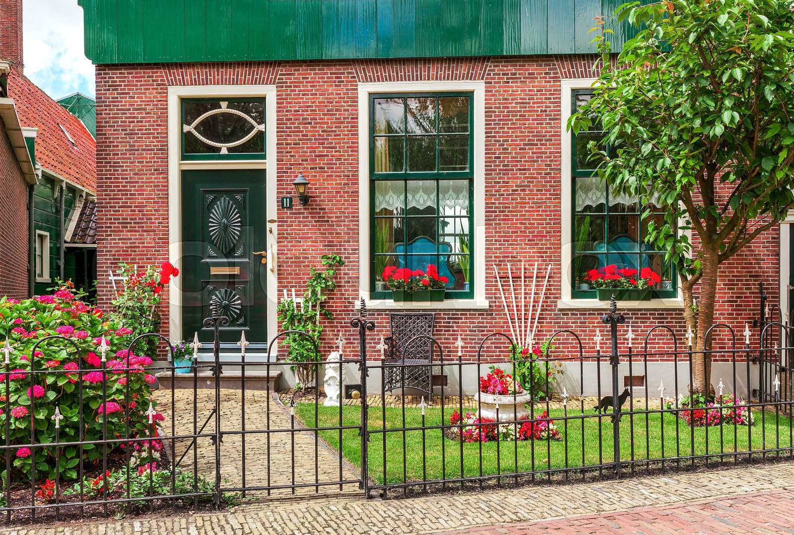 Facade of typical dutch house with small garden and flowers in Zaanse ...
