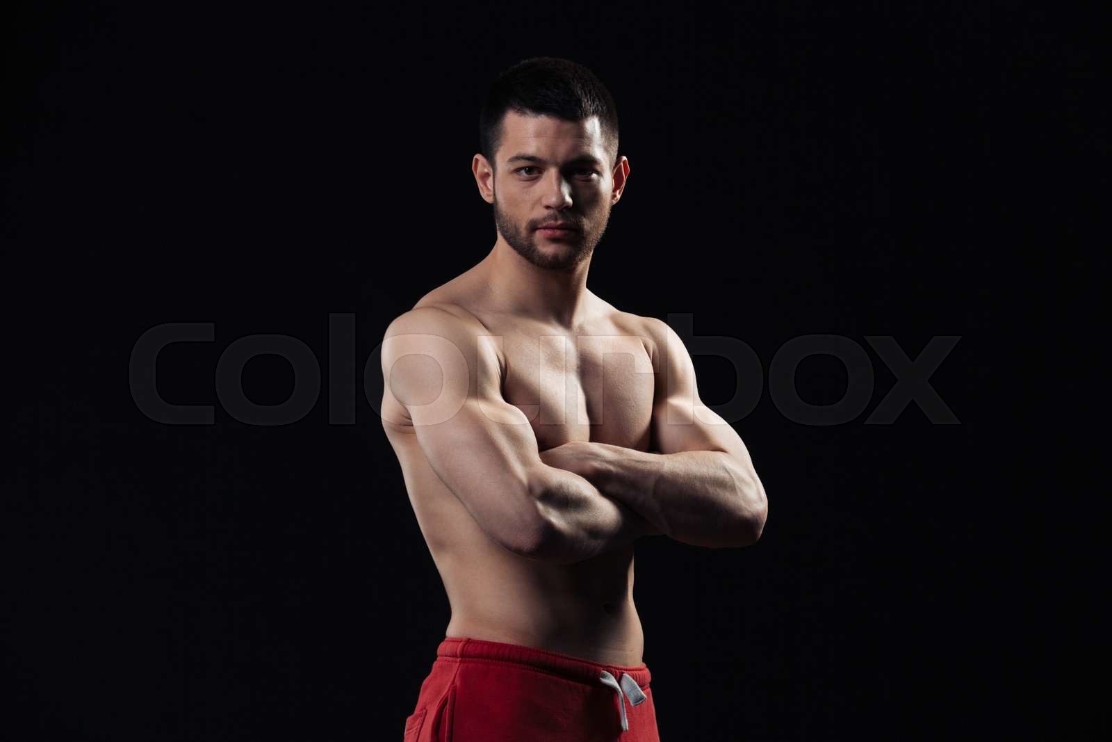 Handsome bodybuilder standing with arms folded | Stock image | Colourbox