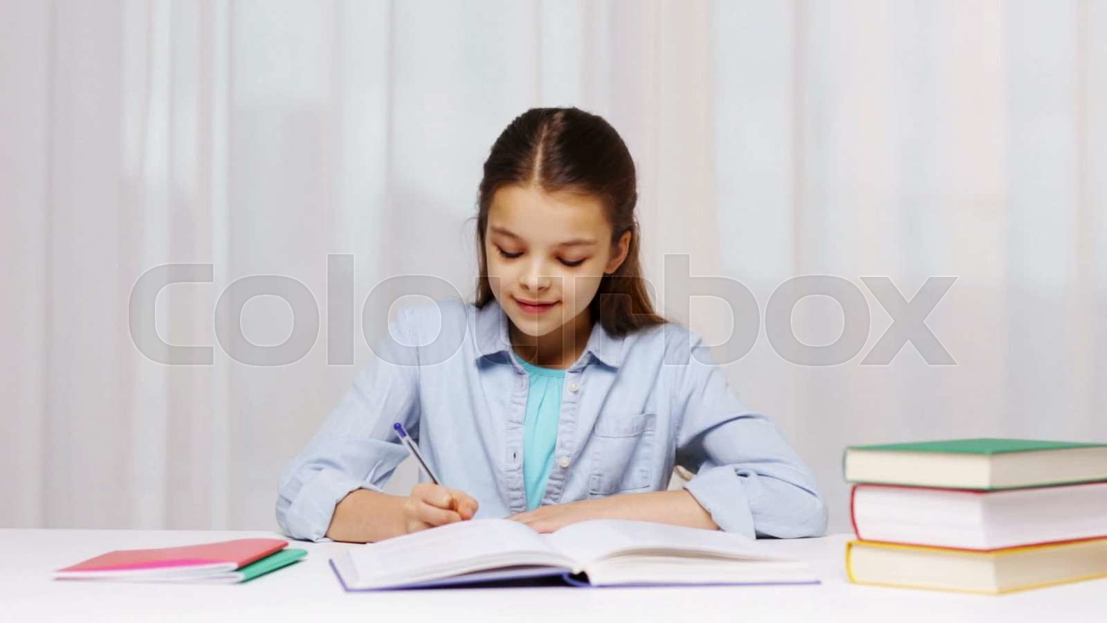 school girl writing math task to notepad | Stock video | Colourbox