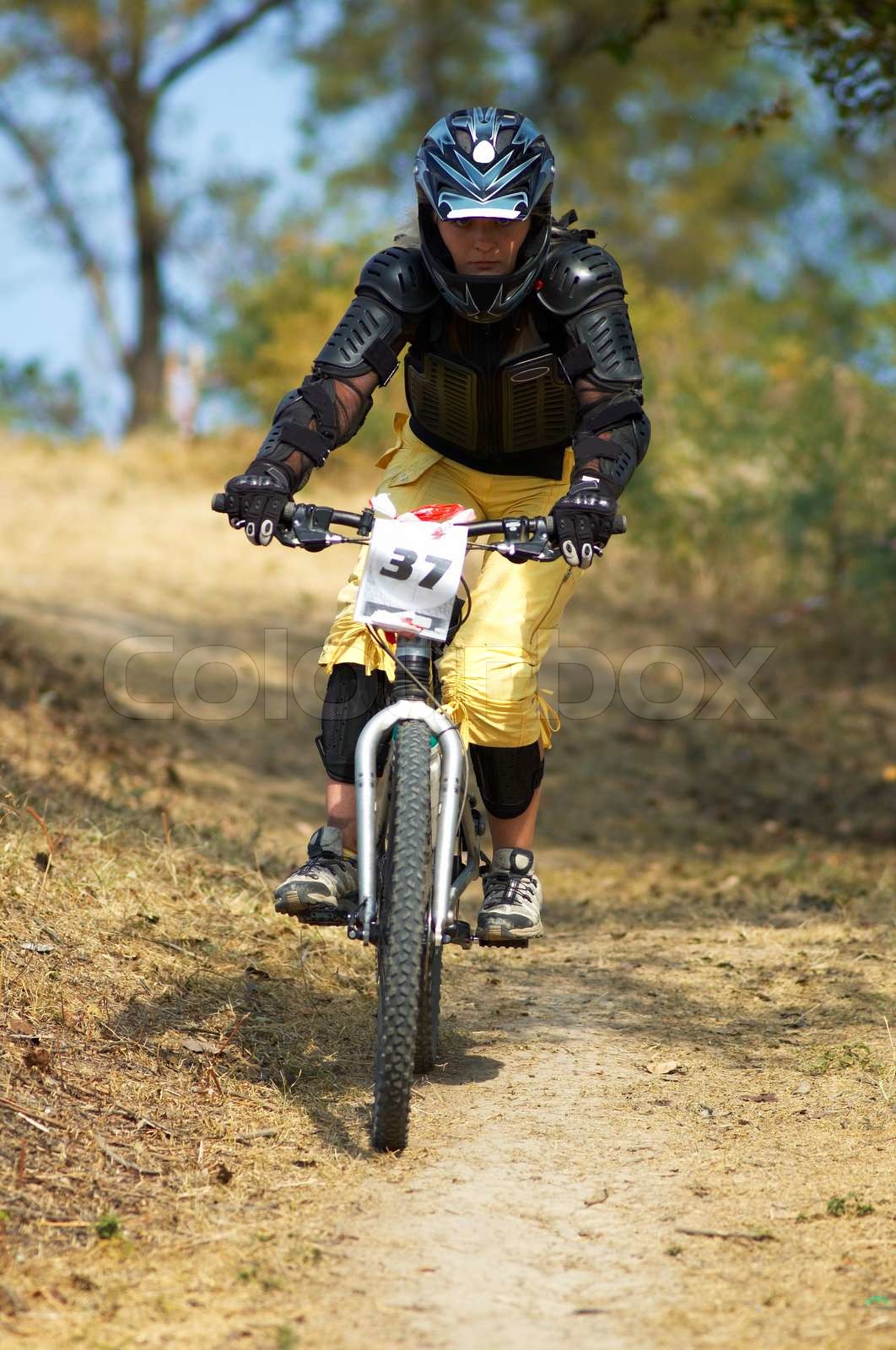 Girl on mountain bike downhill race | Stock image | Colourbox