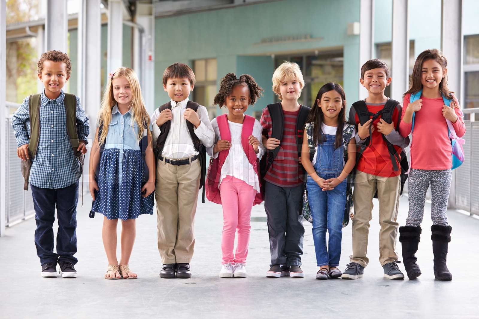 Group of elementary school kids standing in school corridor | Stock ...