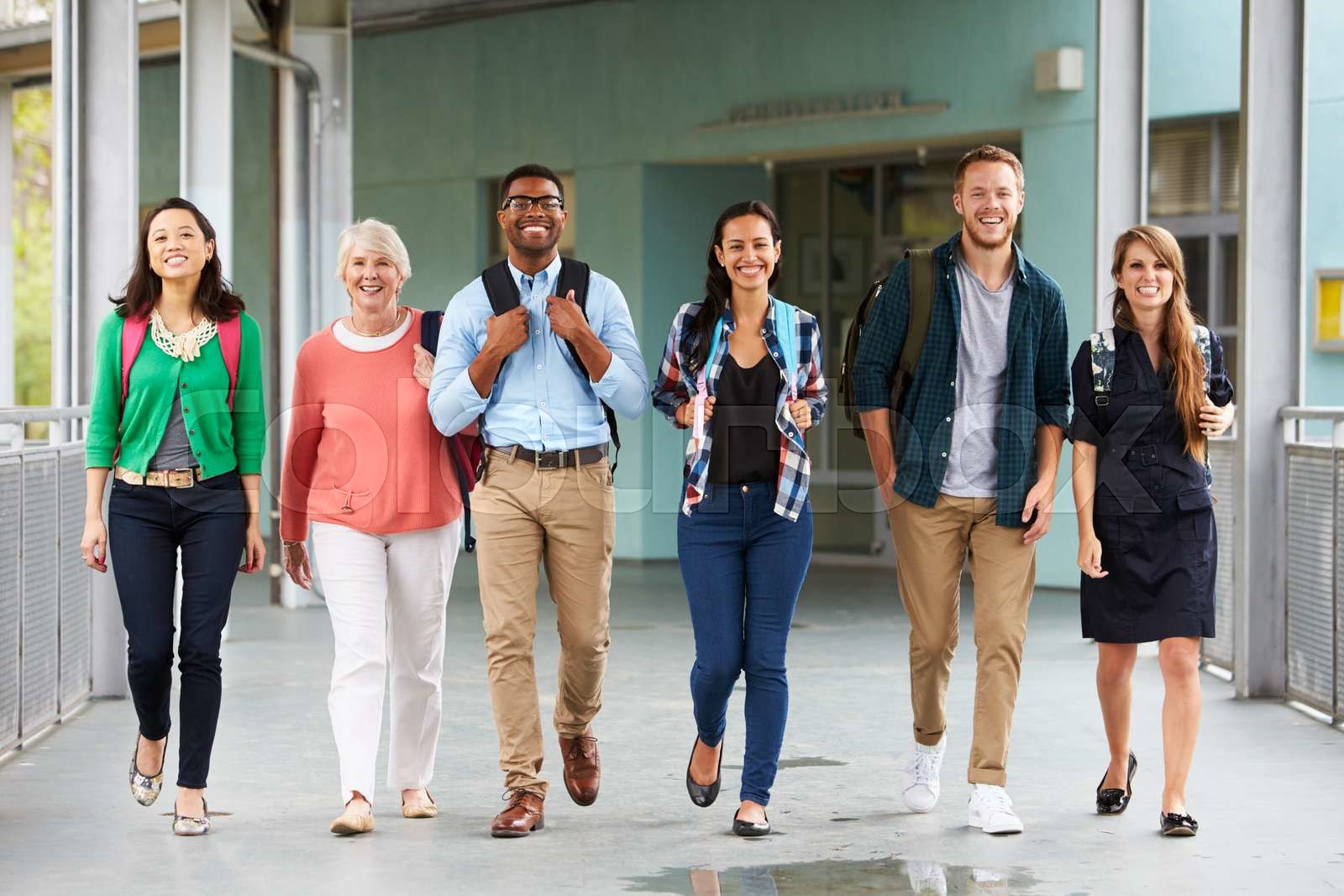 A group of happy teachers walking in a school corridor | Stock image ...