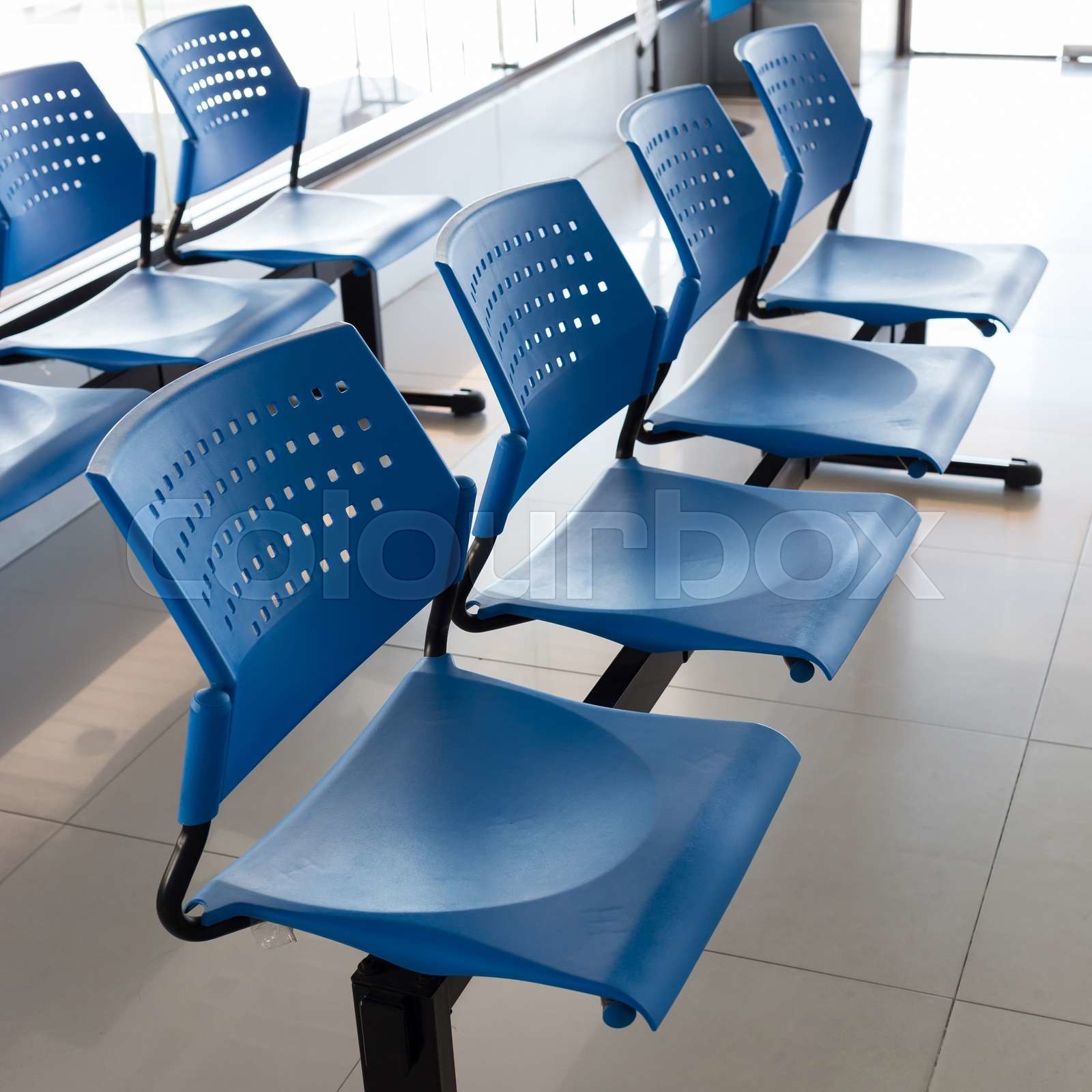 customer waiting area with rows of blue seats in office | Stock image ...