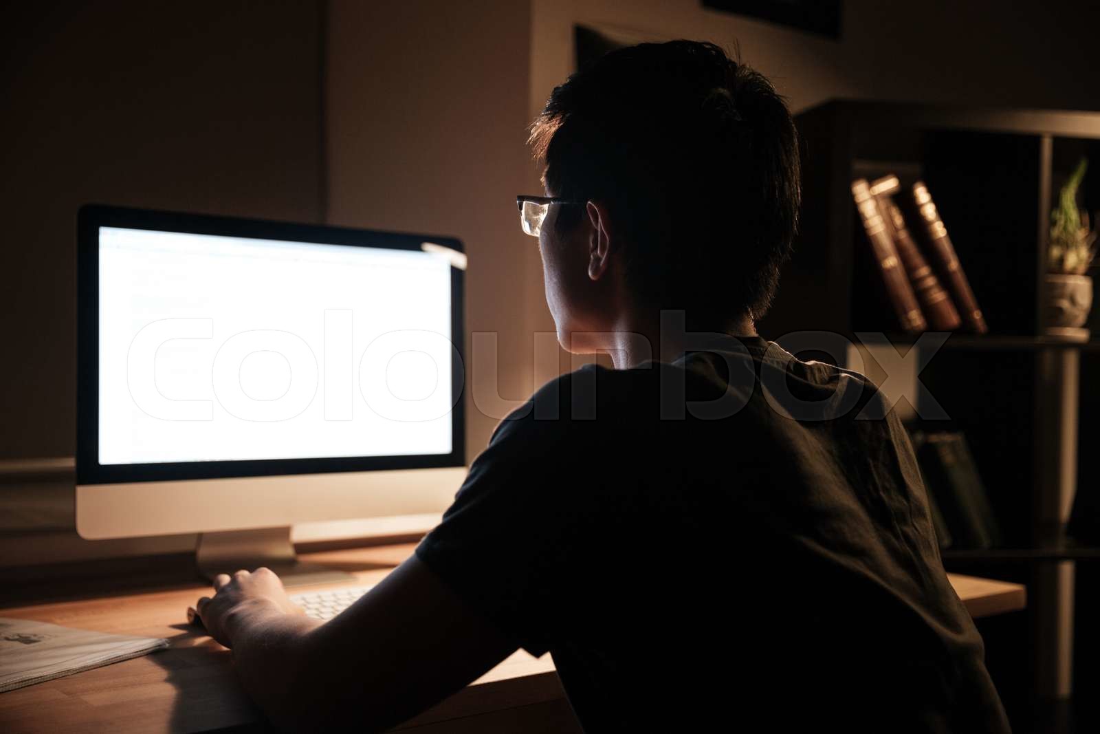 Serious man working with blank screen computer at nighttime | Stock ...
