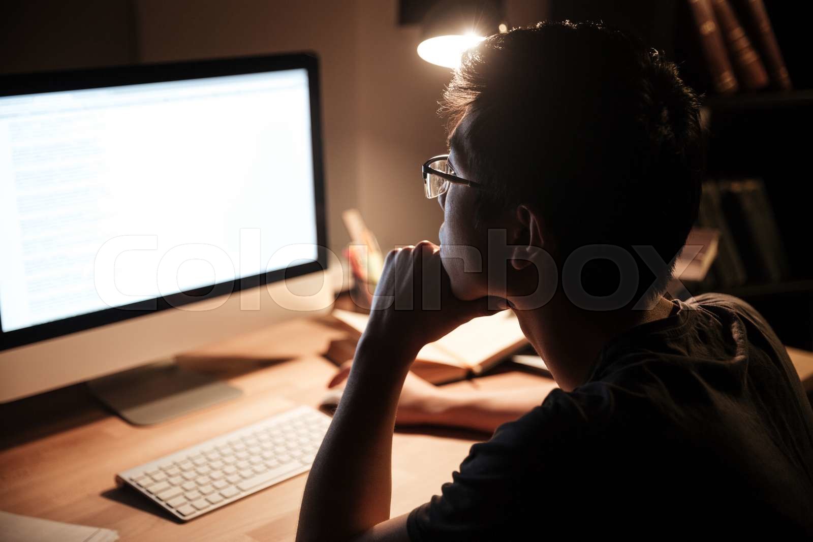 Thoughtful man working with blank screen computer in dark room | Stock ...