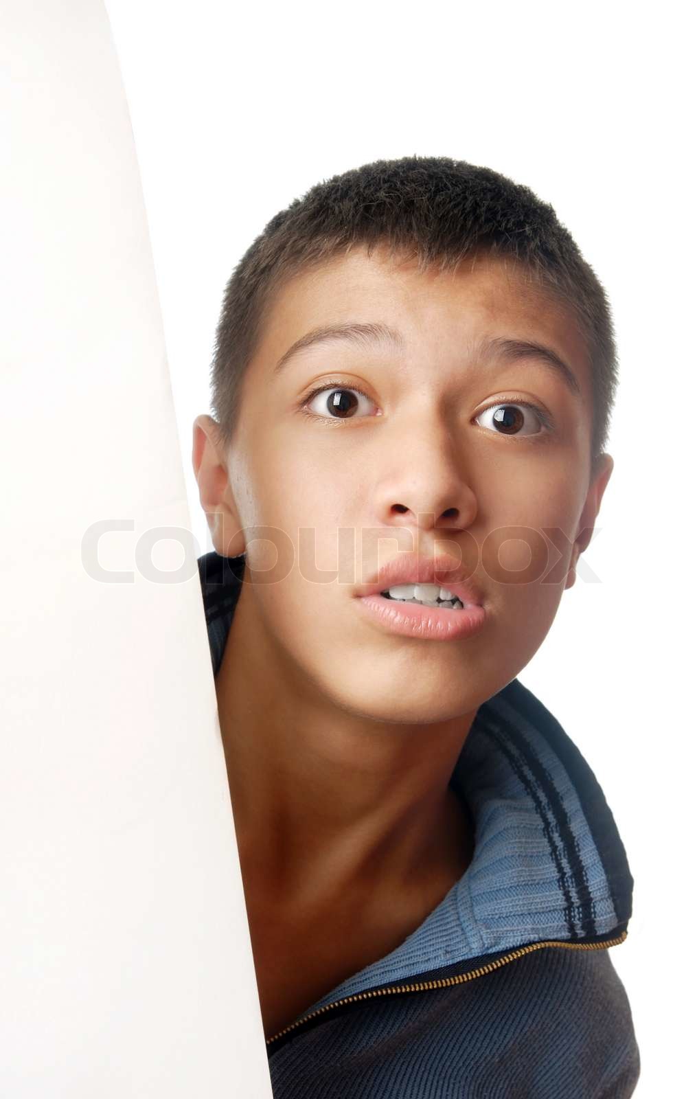 Photo of the afraid boy hiding behind the board | Stock image | Colourbox
