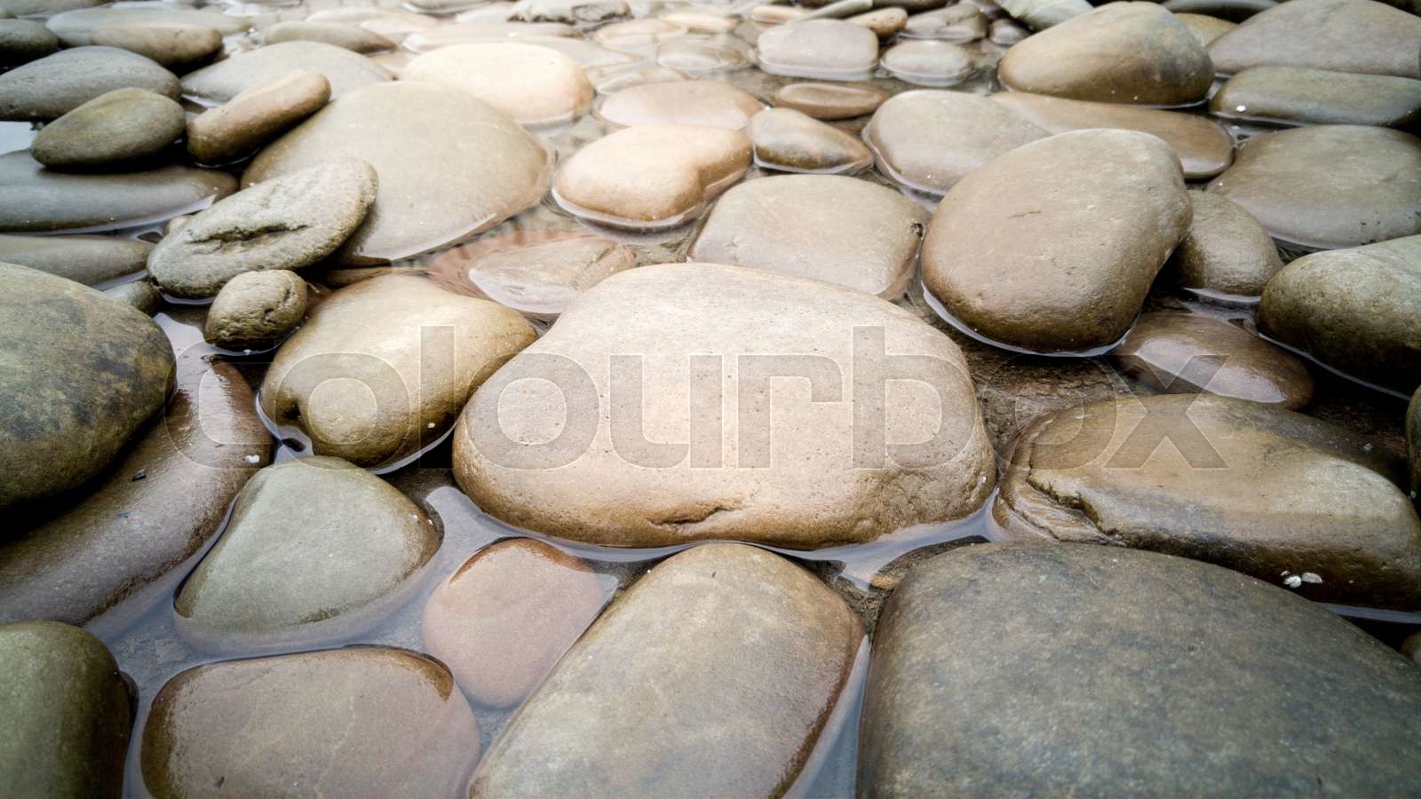 Closeup of big round stones in river | Stock image | Colourbox