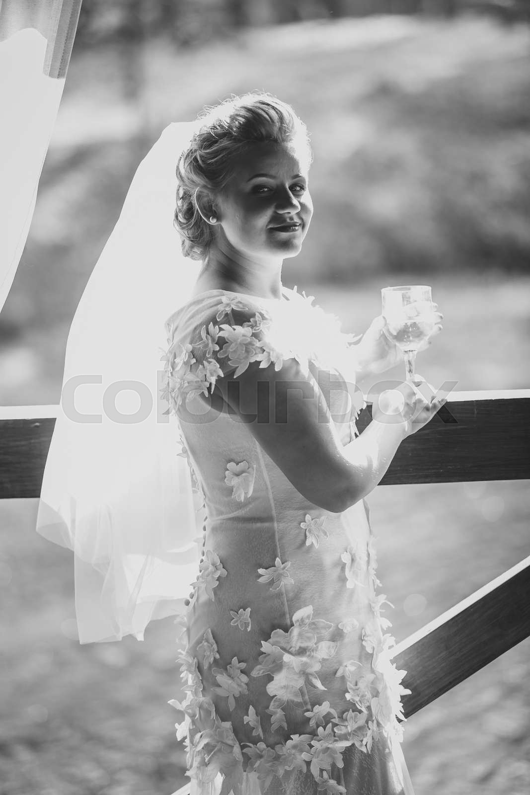 Black and white portrait of elegant bride posing on summer terrace ...