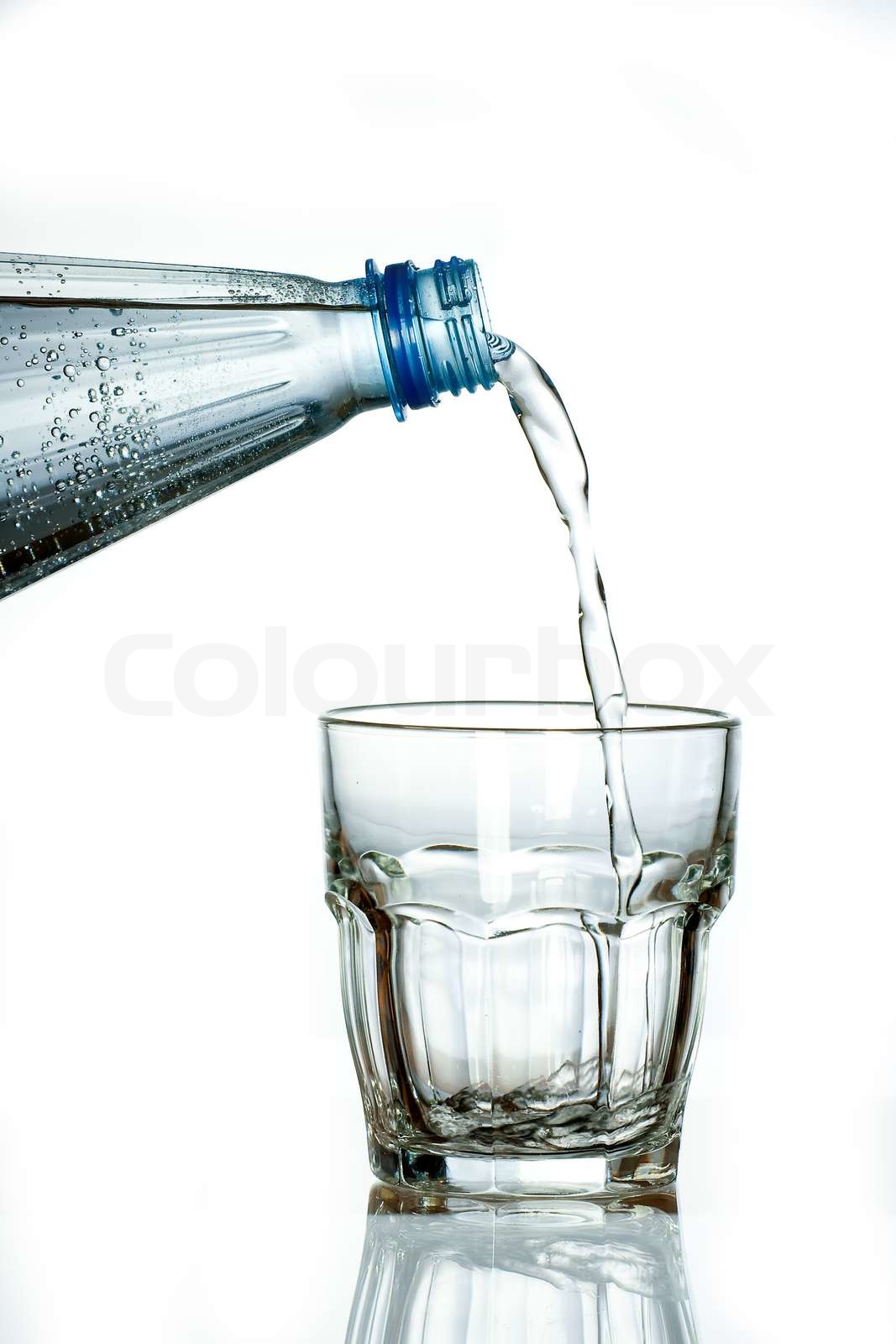 Frisches Wasser wird aus der Flasche ins Glas isoliert auf weißem ...