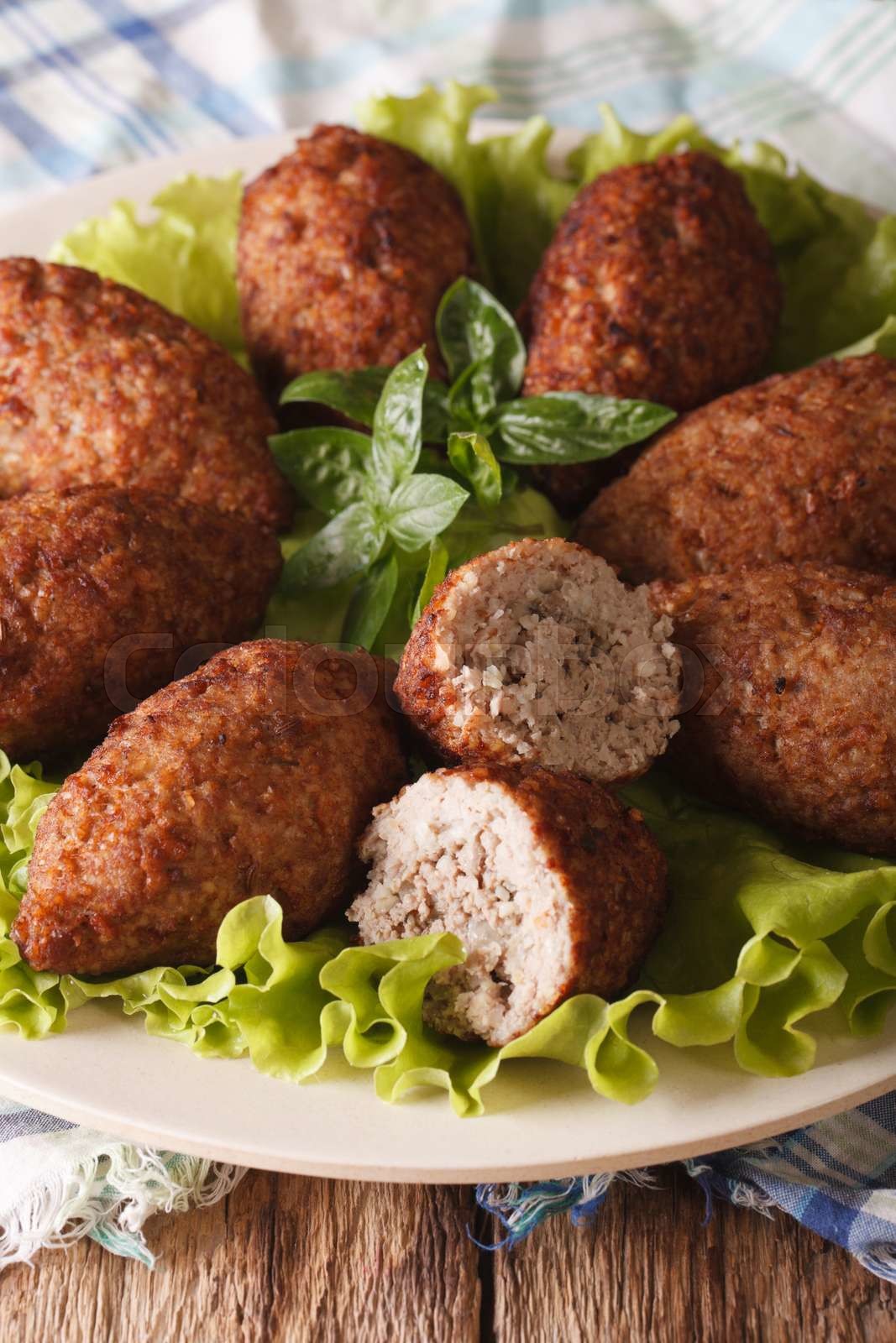 Arabic kibbeh with bulgur and pine nuts on a plate macro. vertical ...